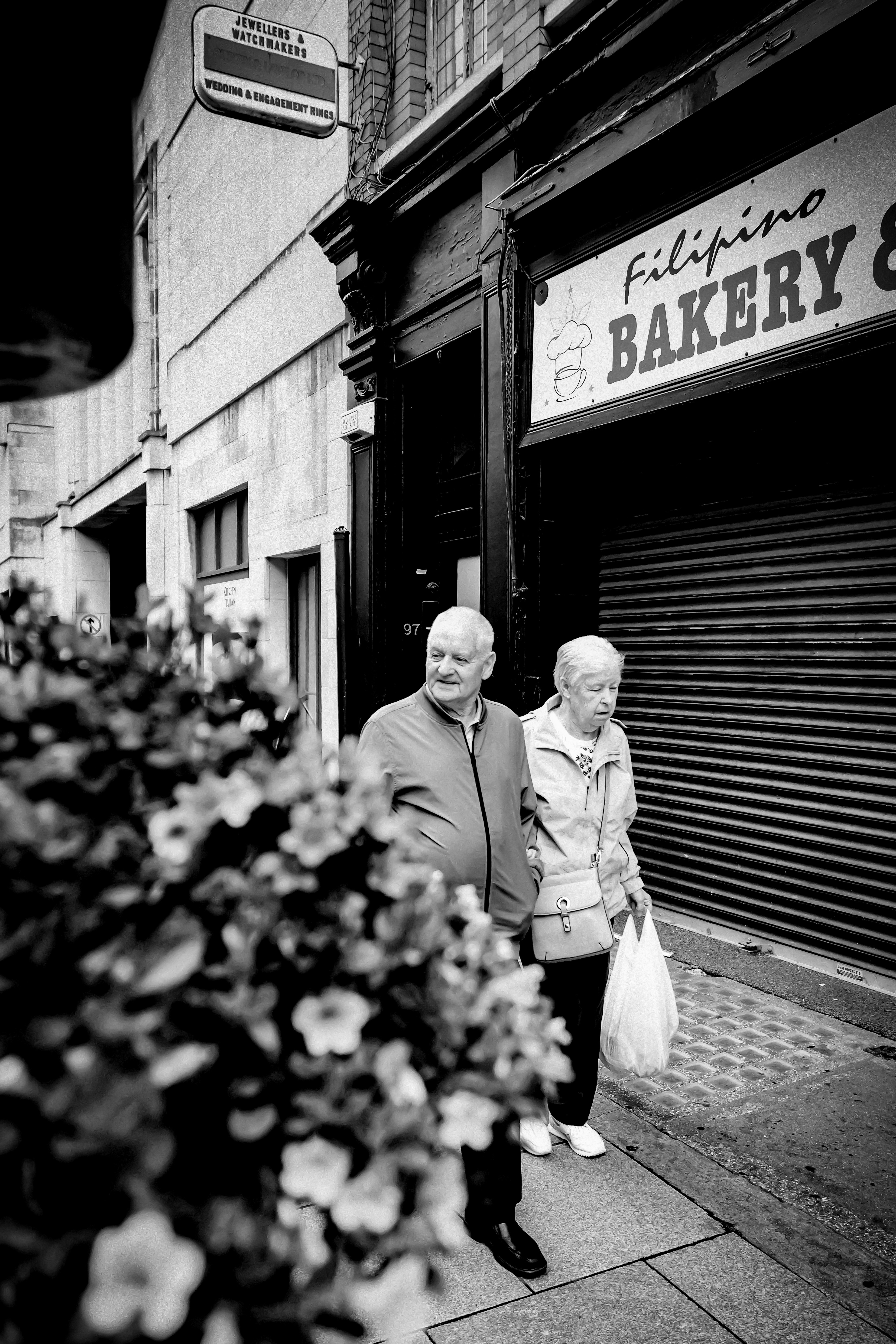 Couple Steps Through Time Along a Quiet Bakery Façade