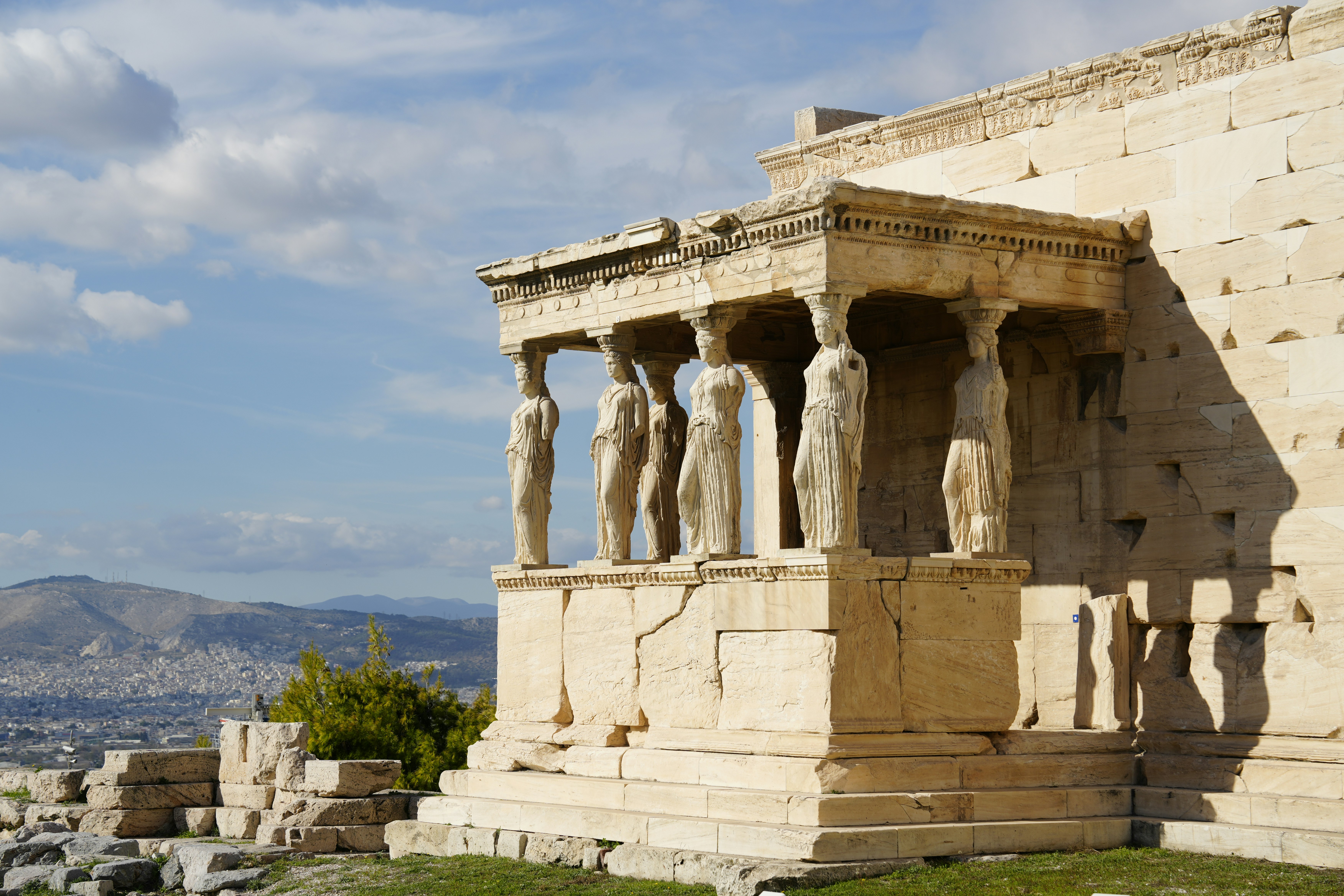 Parthenon Frieze Guardians: A Closer Look at Stone Carved Figures Against Aegean Backdrop
