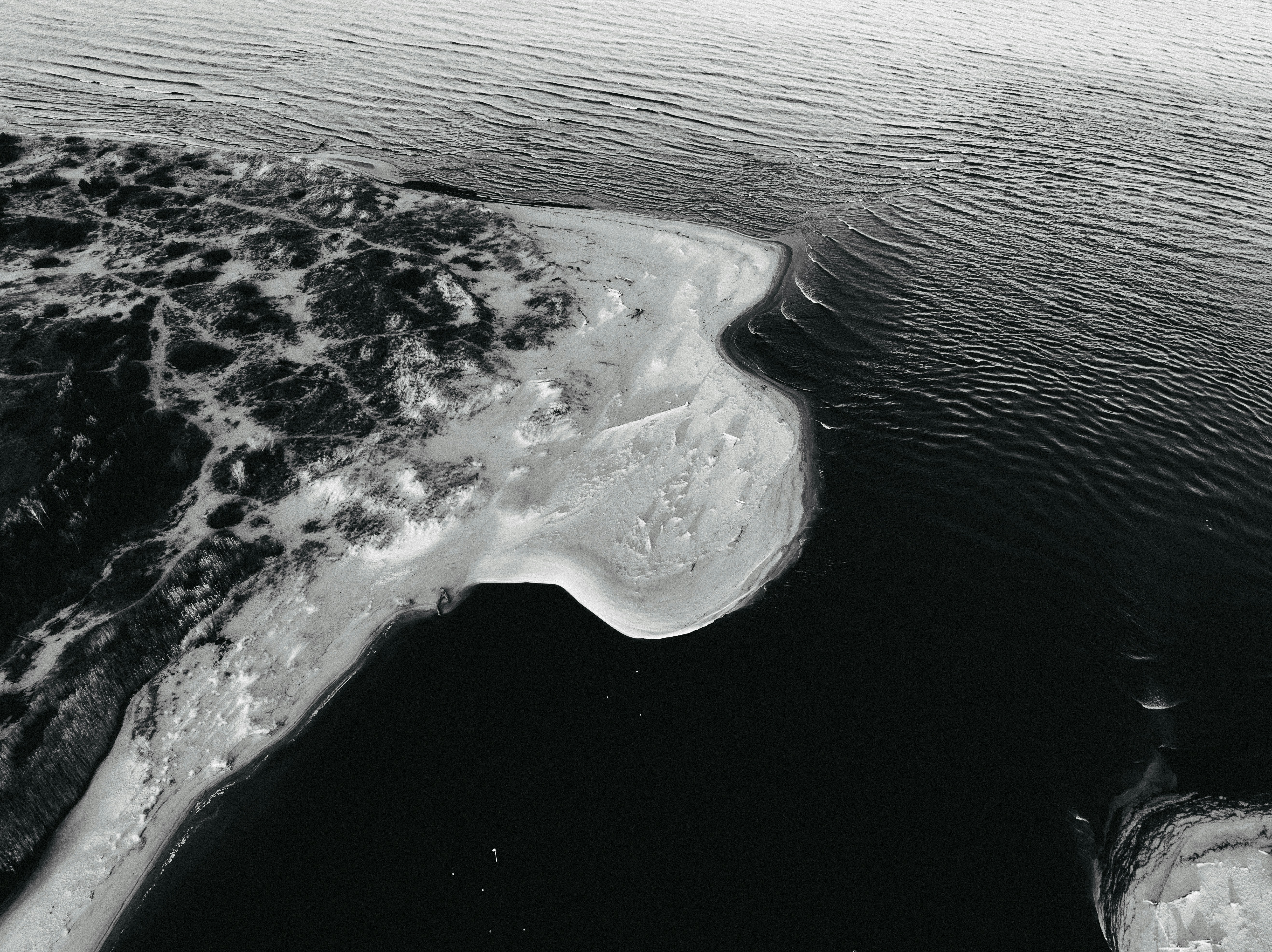 Aerial view of a sandy spit jutting into dark water photo – Free Beach ...