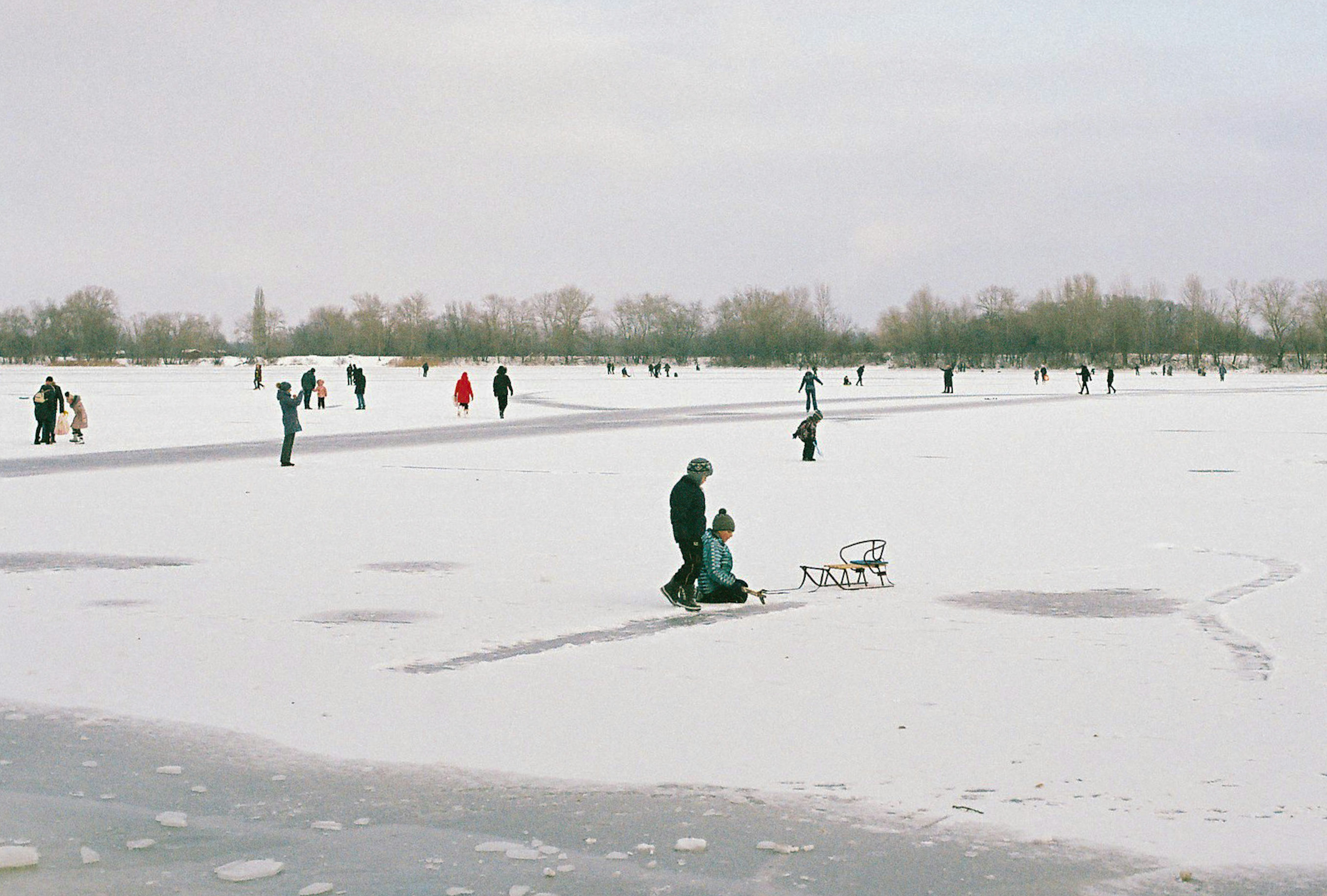 People ice skating and sledding on a frozen lake. photo – Free Portrait ...