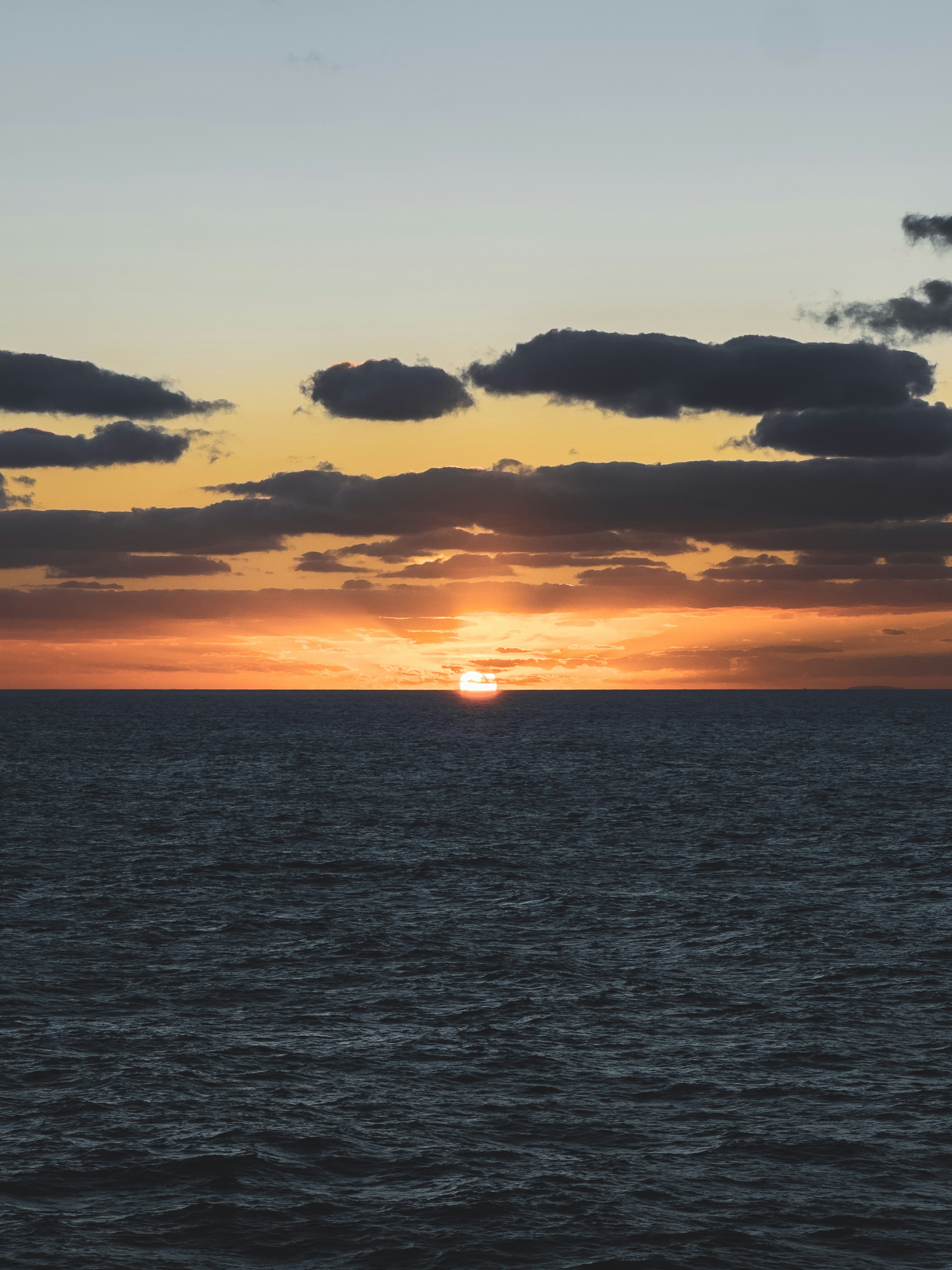 Sunlit Horizon: Sunset Over Calm Seas