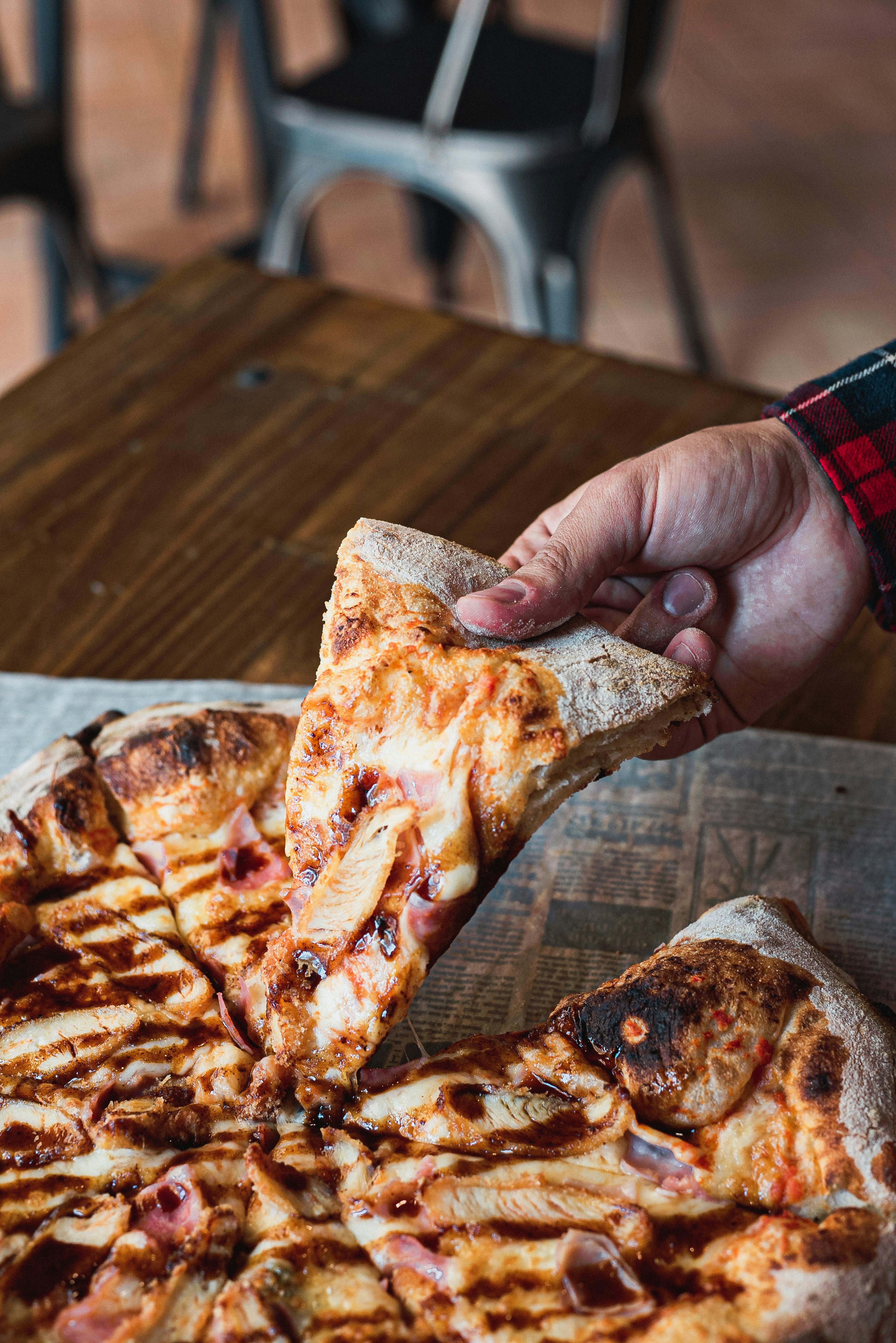Hand taking a slice of pizza from a whole pizza. photo – Free Hand ...
