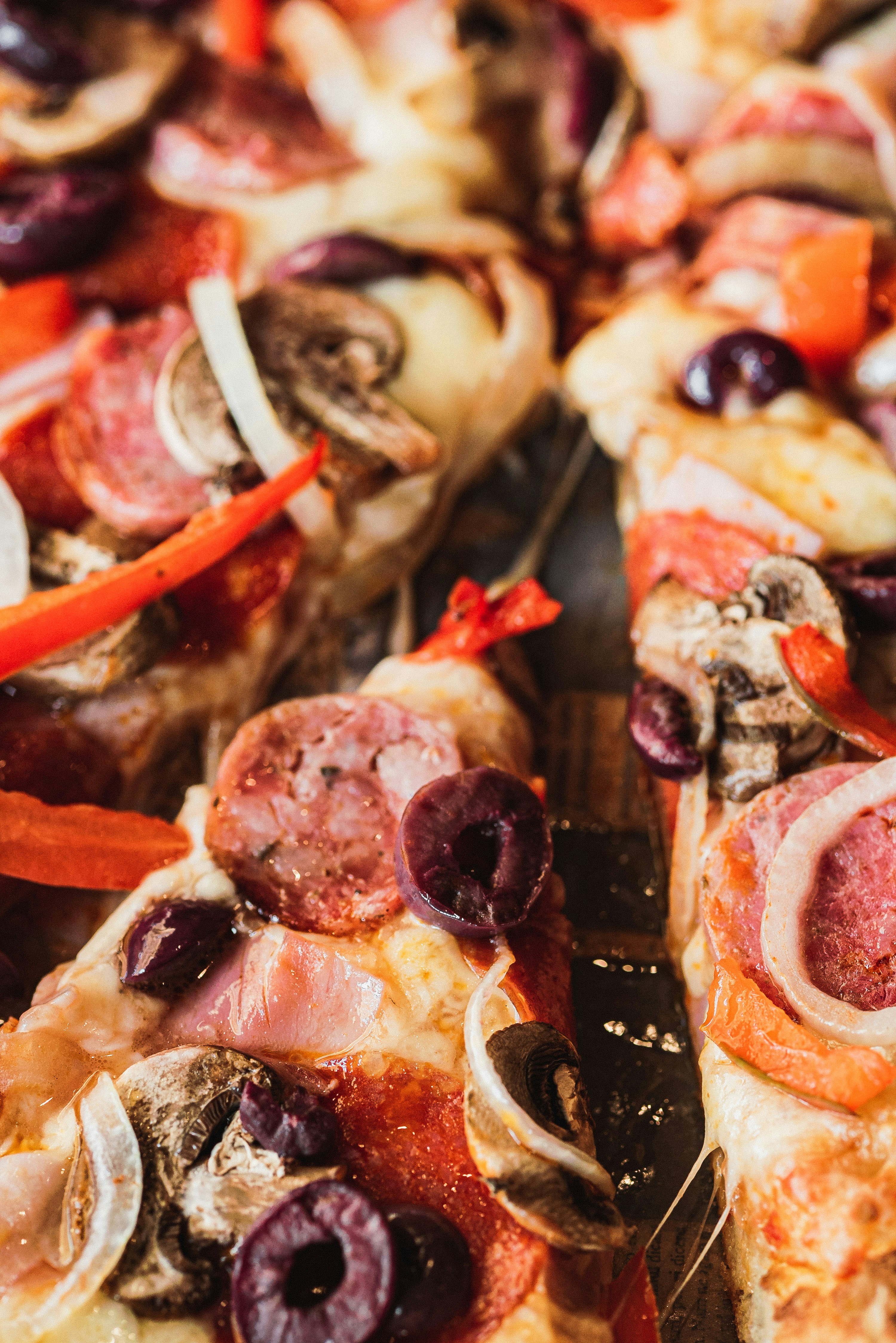 Meat Lovers Pizza Slices Crowned with Olives and Roasted Veggies