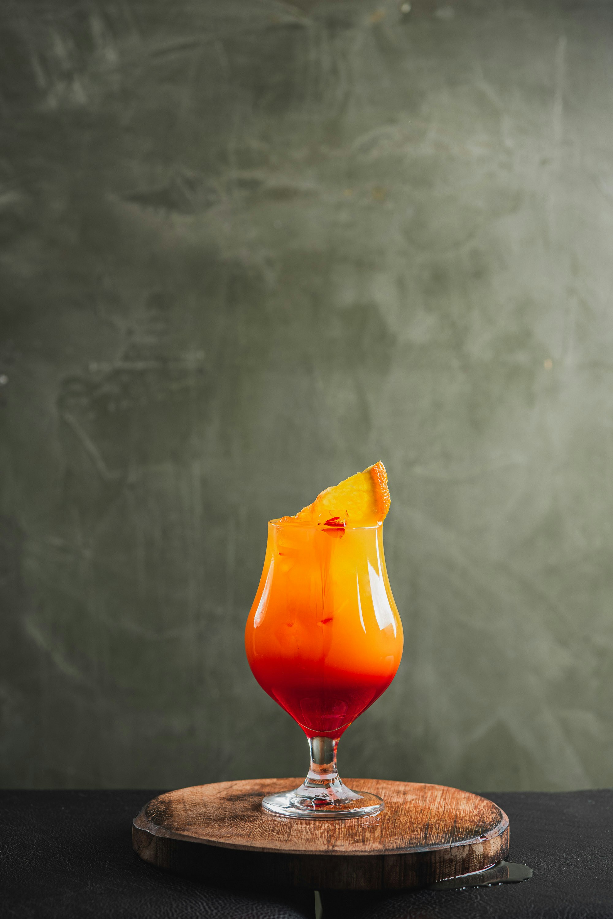 Sunset in a Glass: A Tropical Cocktail on a Wooden Pedestal