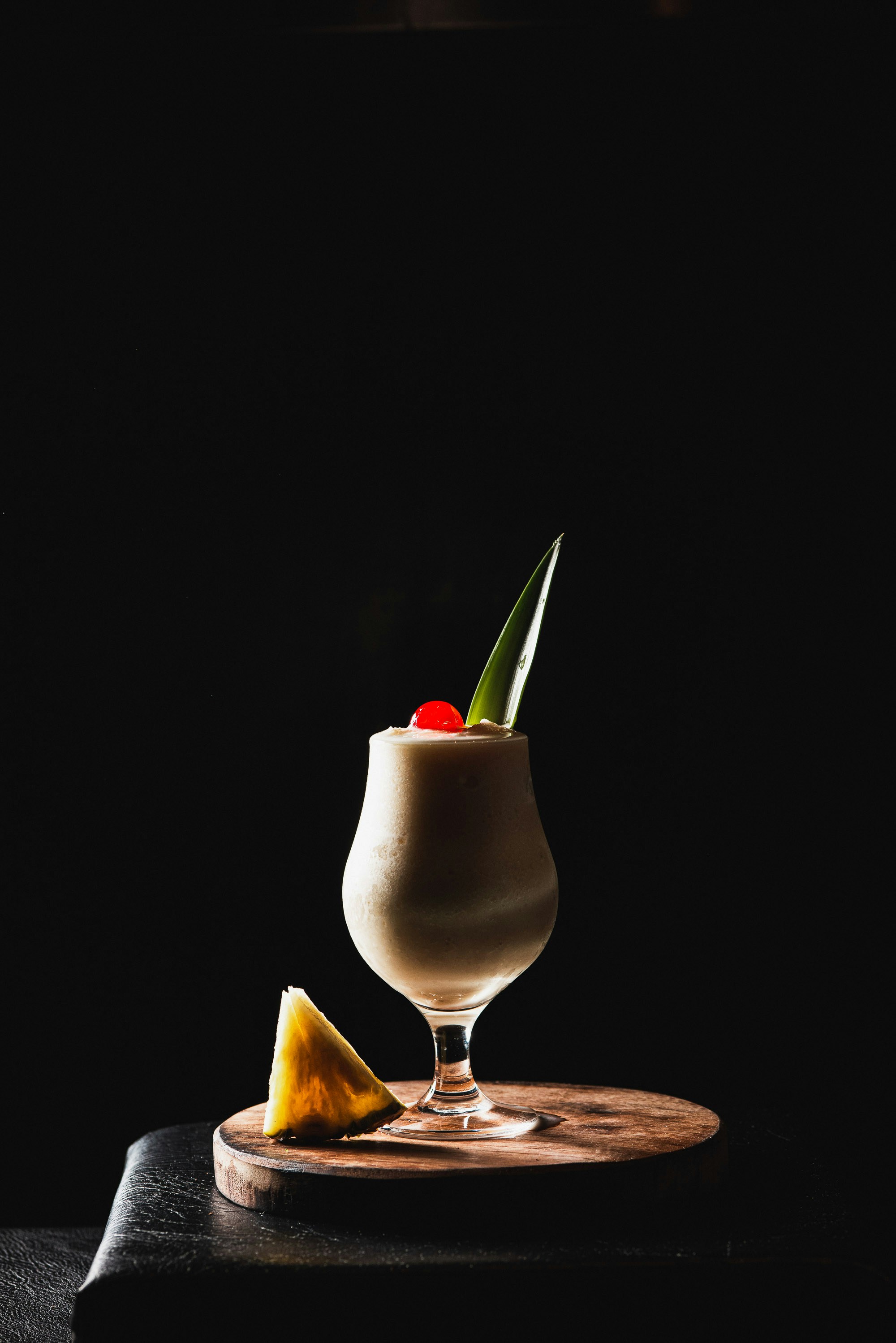 Tropical glow: a creamy cocktail crowned with pineapple and leaf