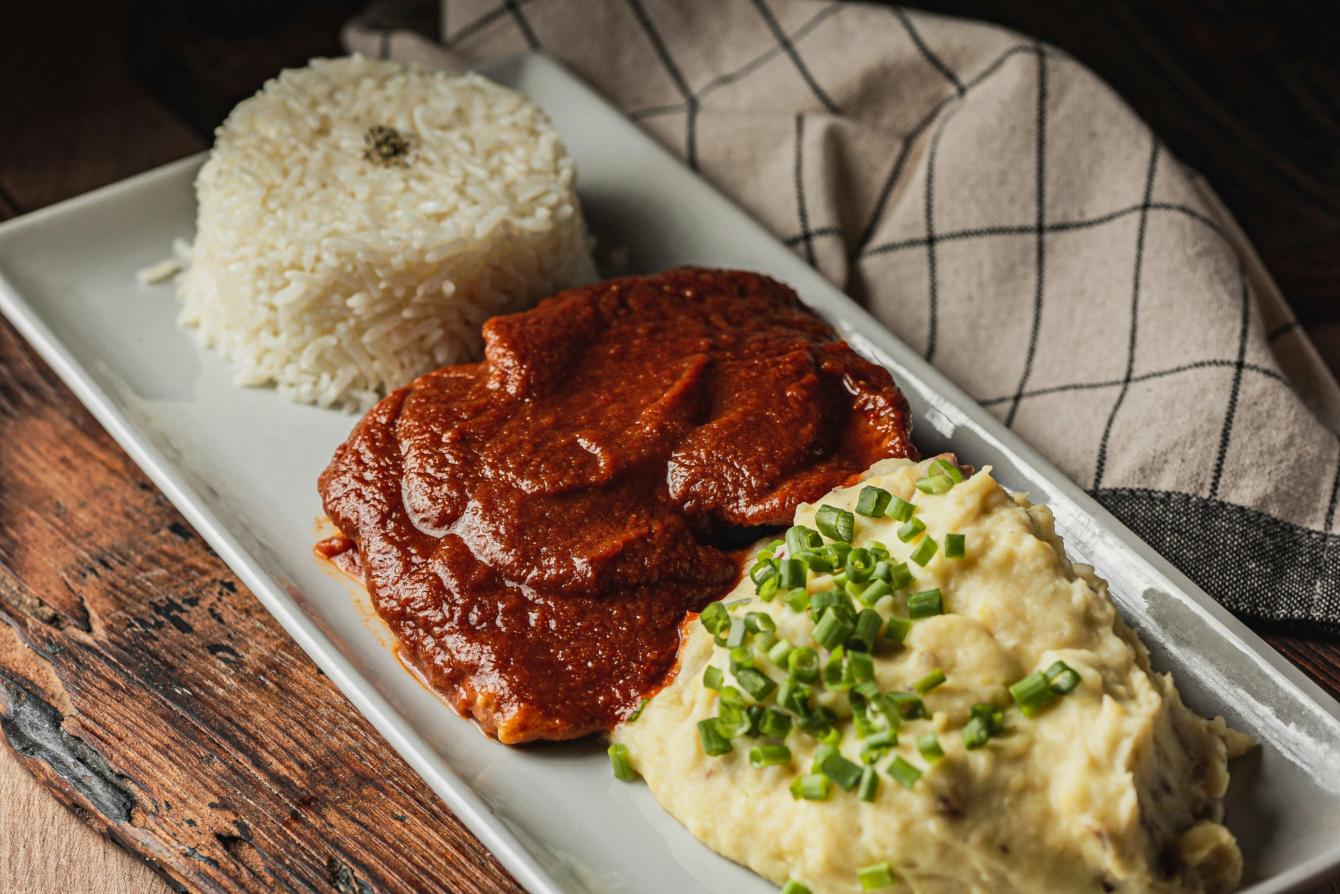 Savory Triad: Rotisserie Meat with Creamy Mash and Herb Garnish