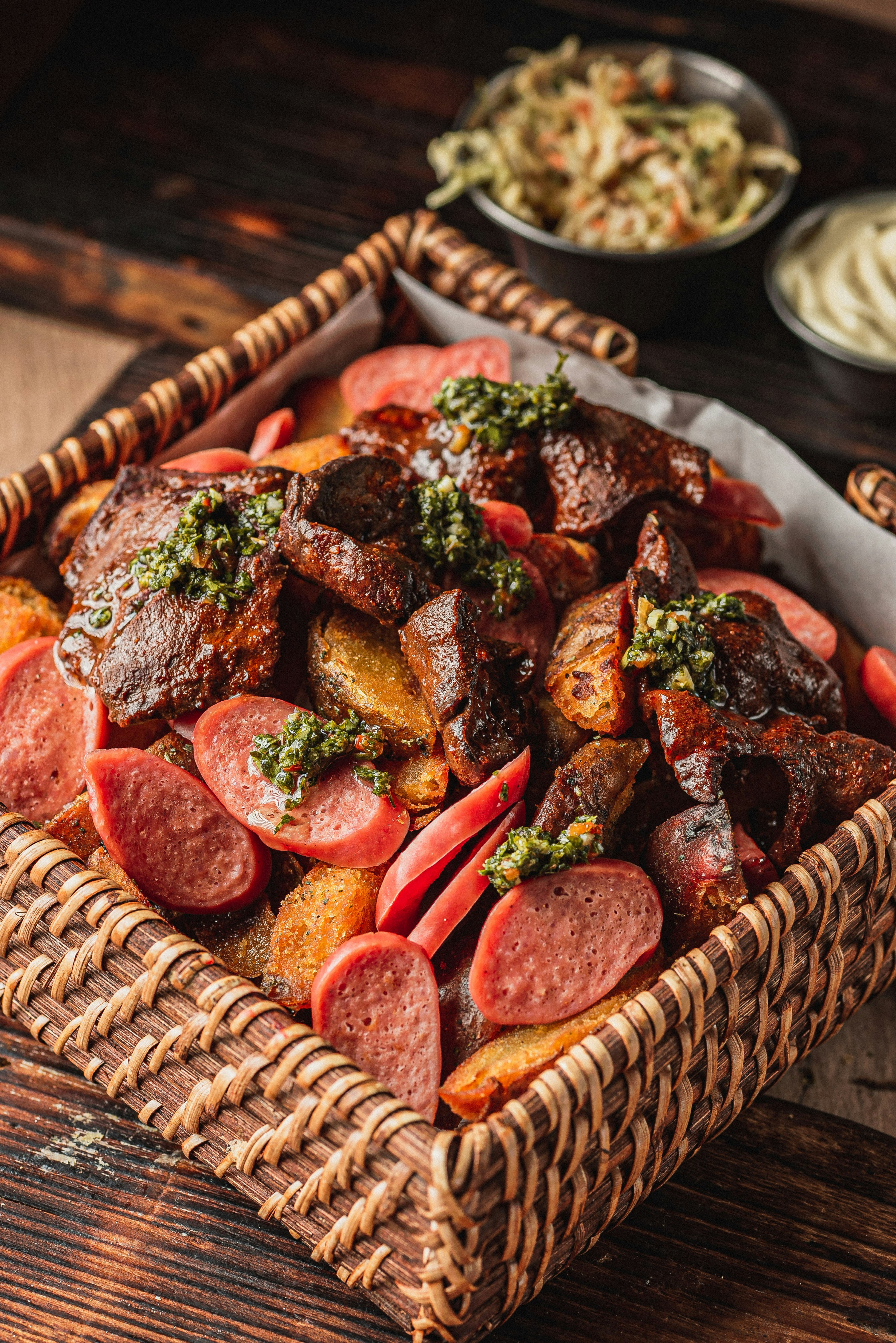 Charred morsels of sausage and roasted meat nestled in a woven basket