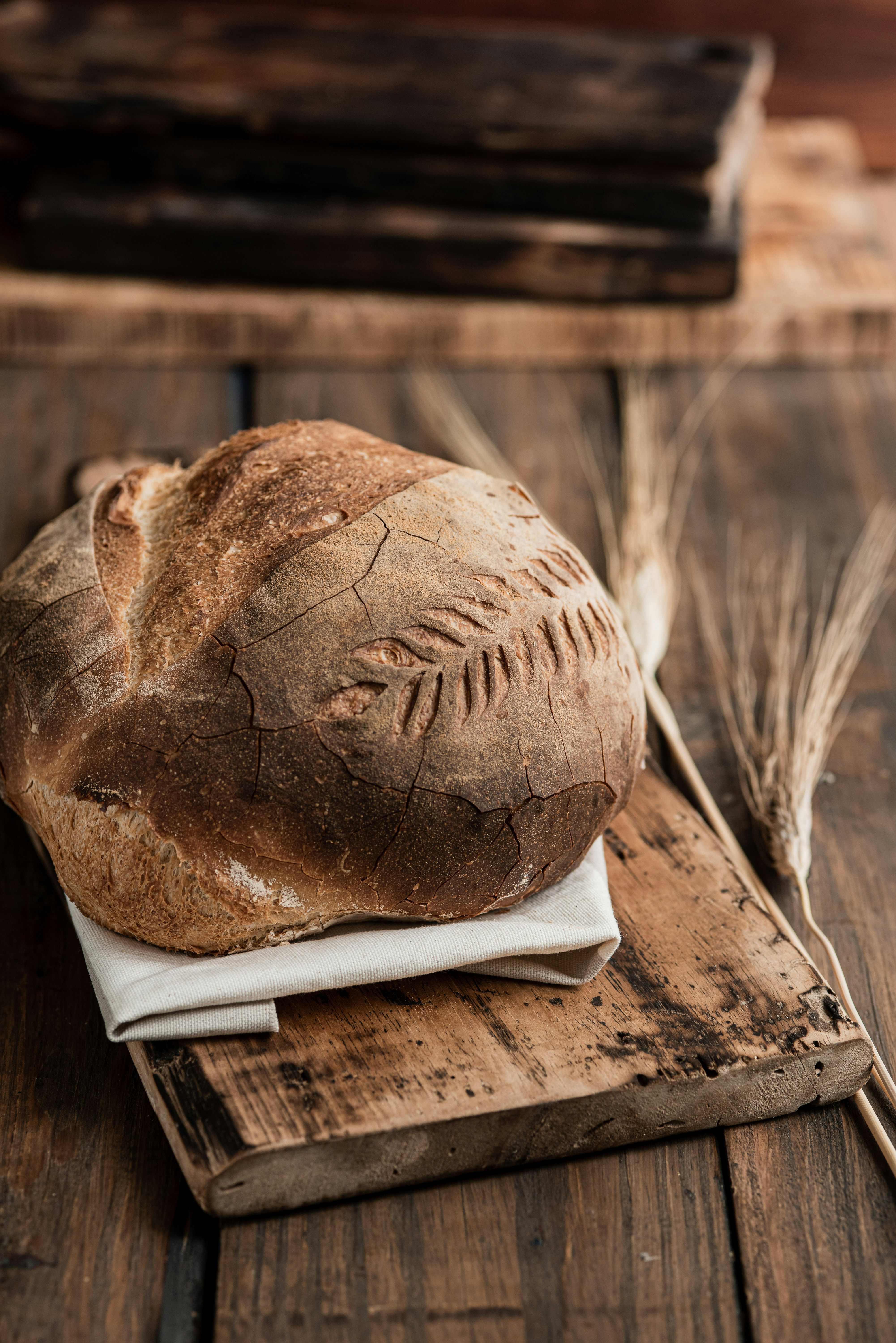 Cracked rustic loaf resting on a weathered cutting board