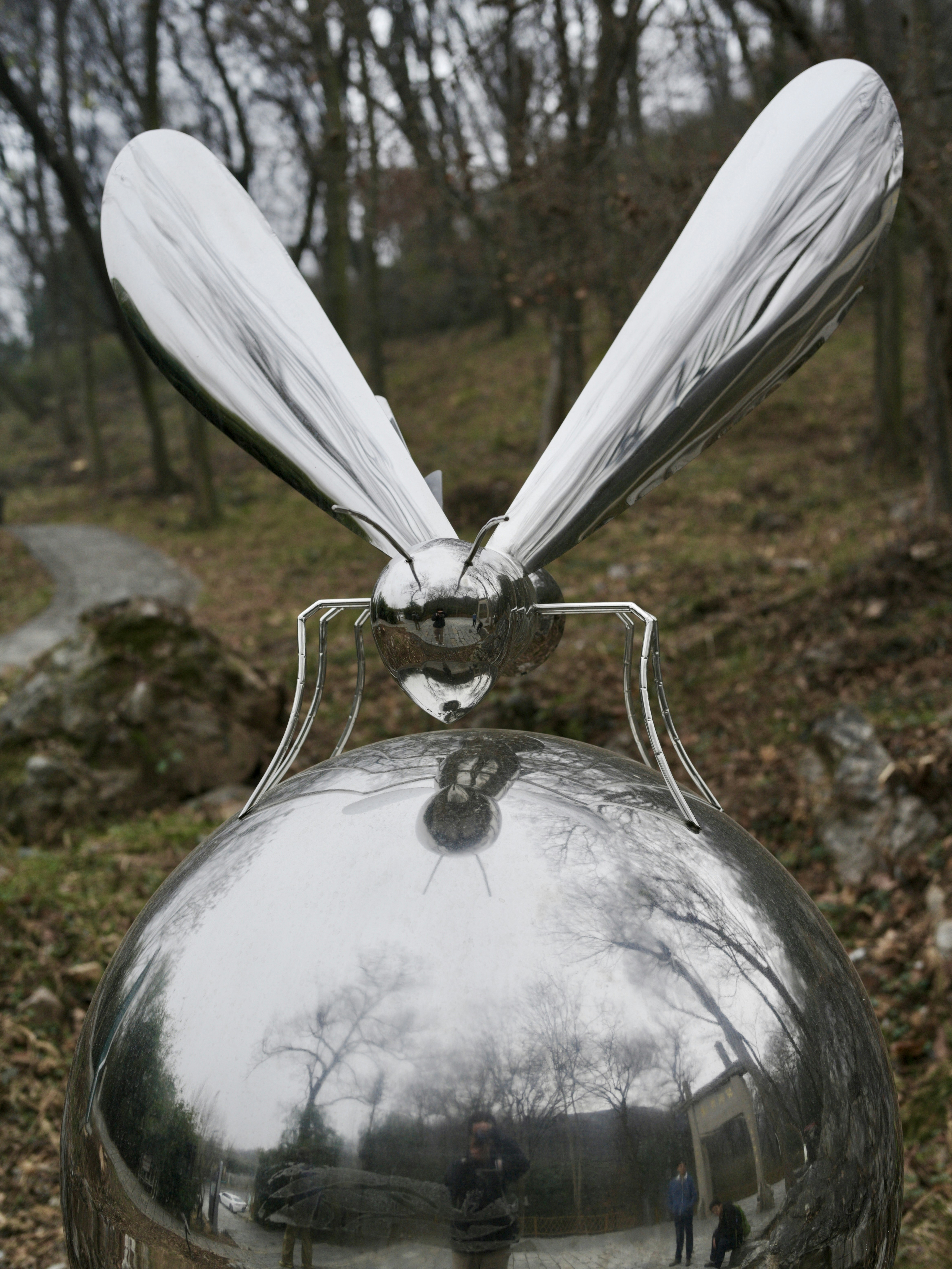 Shimmering Carved Echo: A polished rabbit sculpture peering into the woods