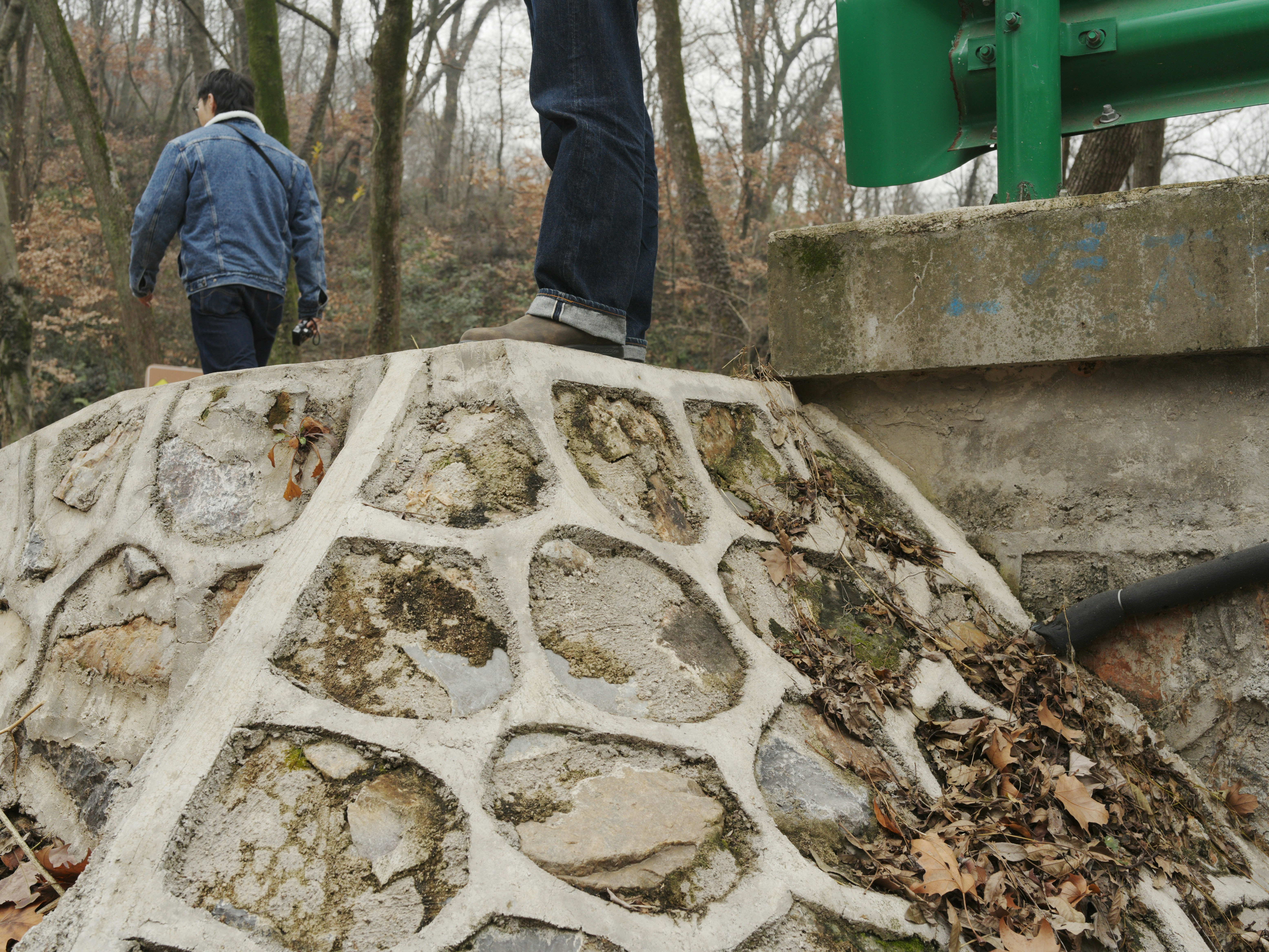 Lone Visitor Steps Up the Stone Ramp Beneath a Bridge