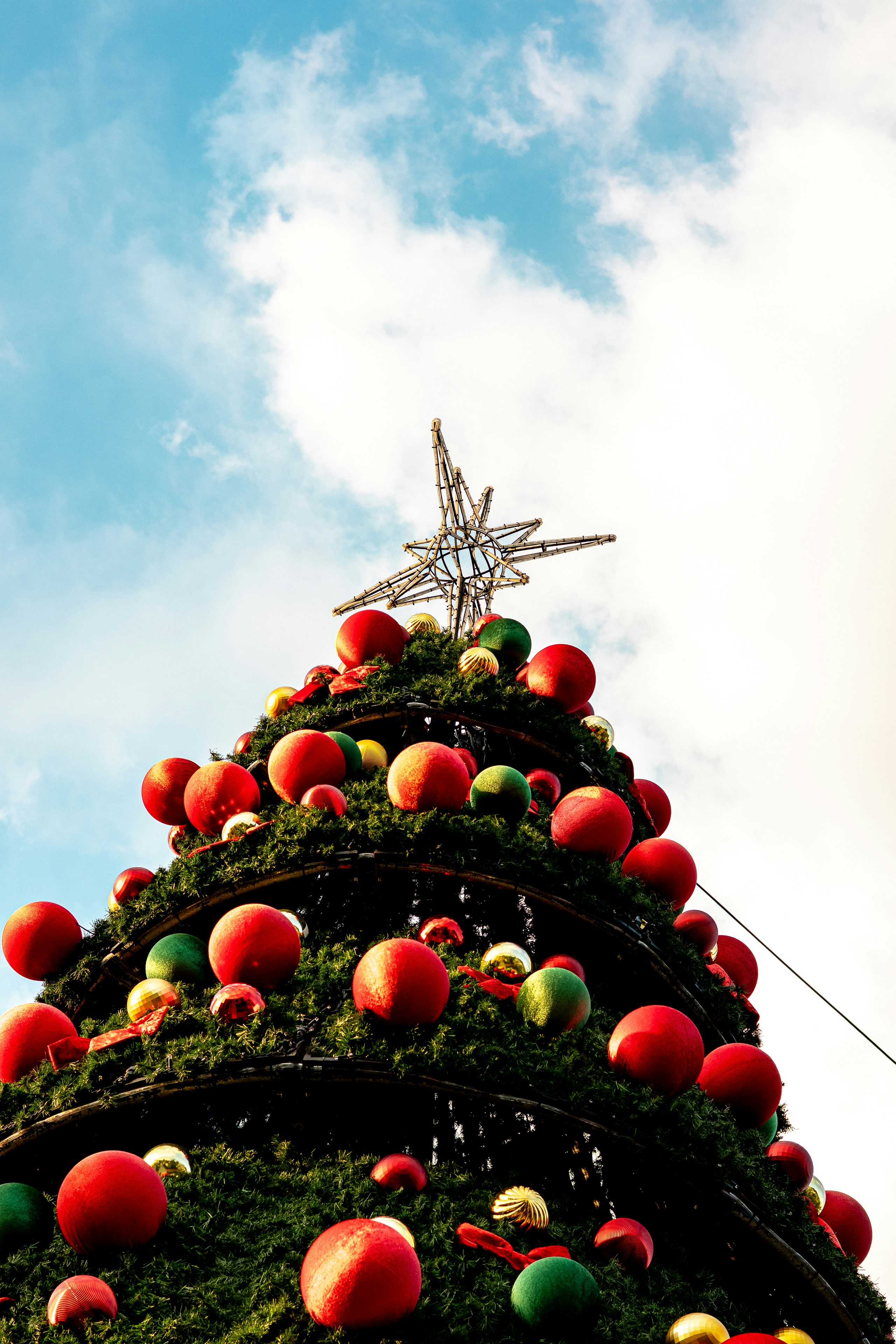 Ornamented Peak: A Christmas Tree Crowned with Red and Green Spheres Reaching the Sky