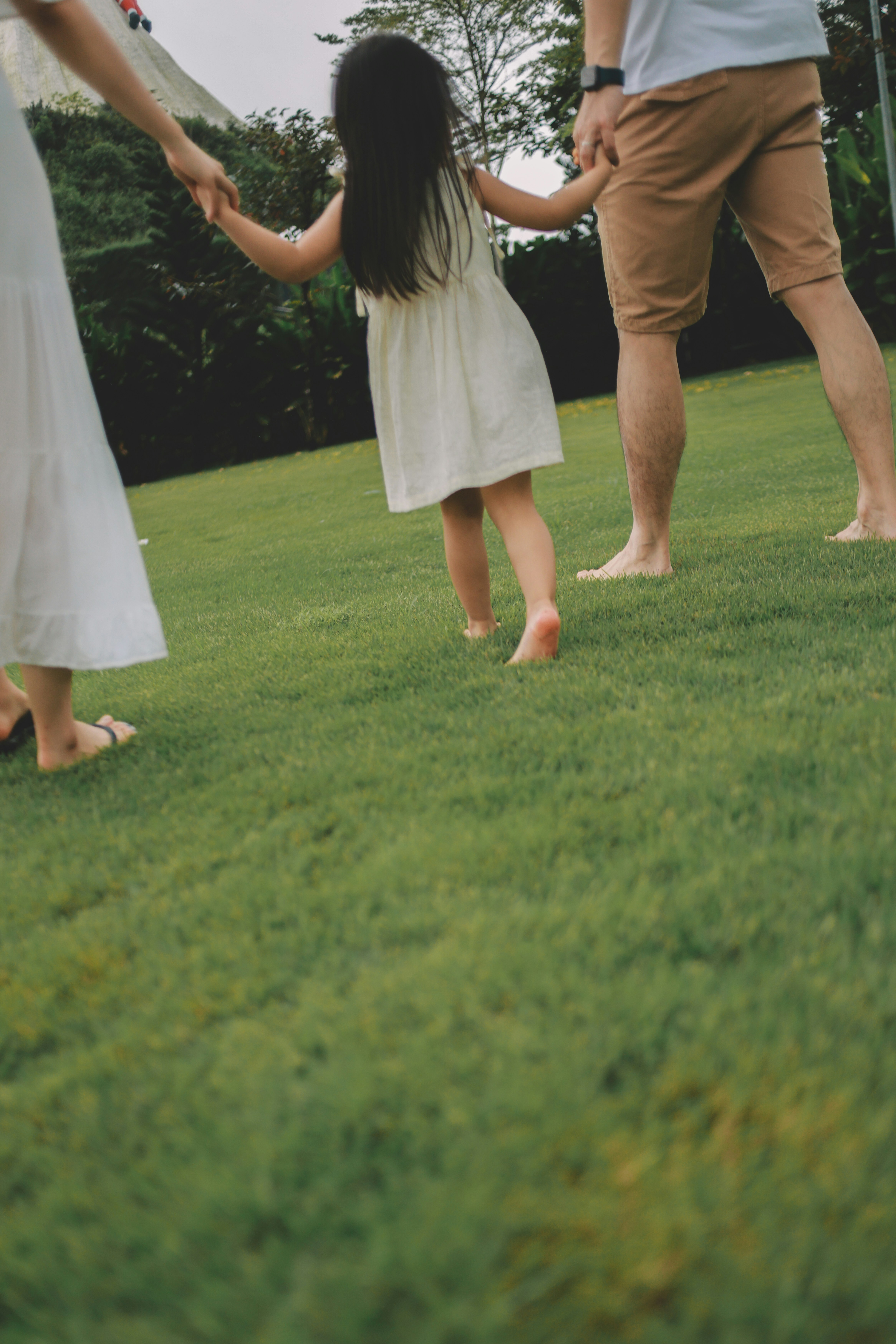 Holding Hands on the Green: A Family Moment in the Yard