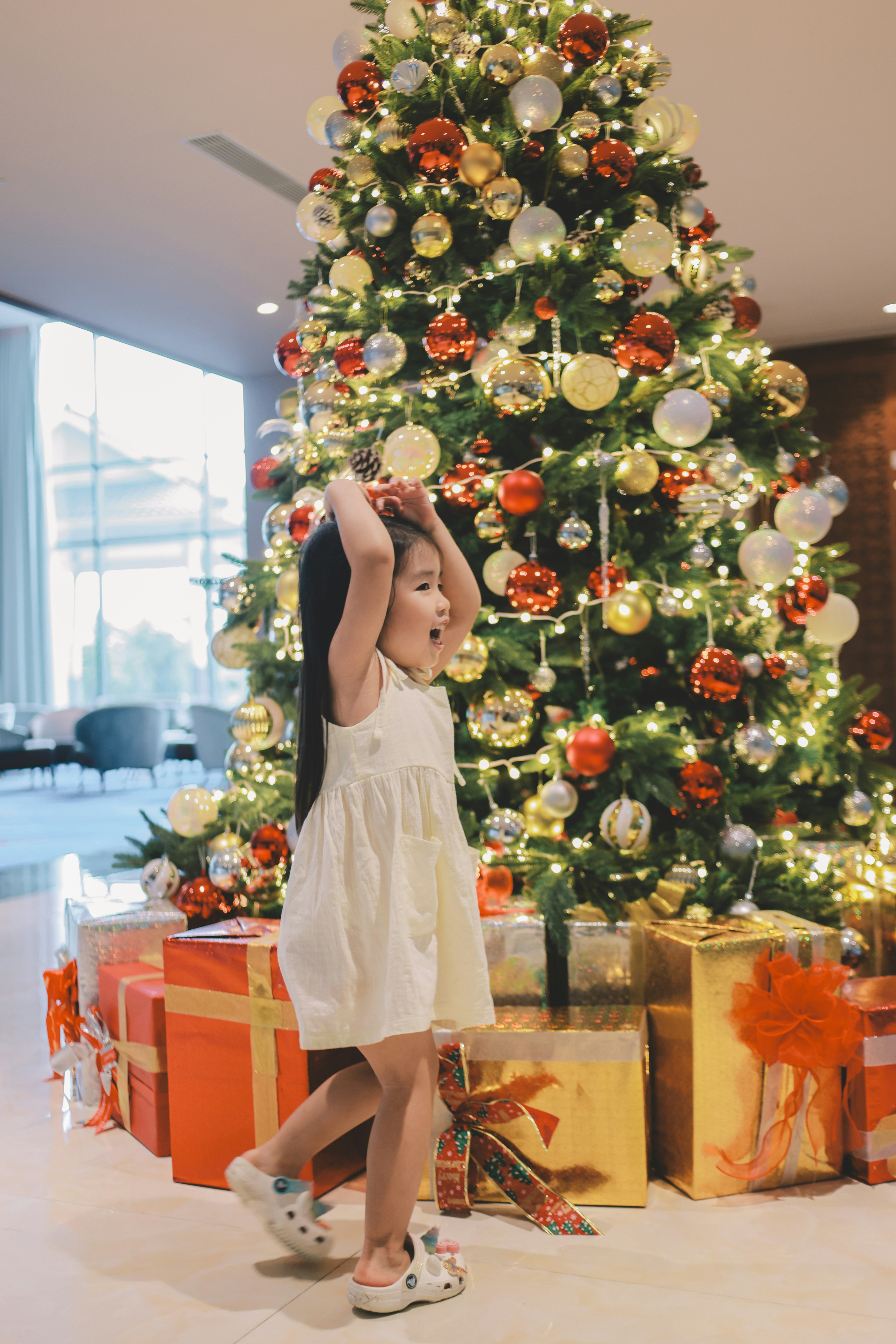A young girl poses by a decorated christmas tree. photo – Free ...