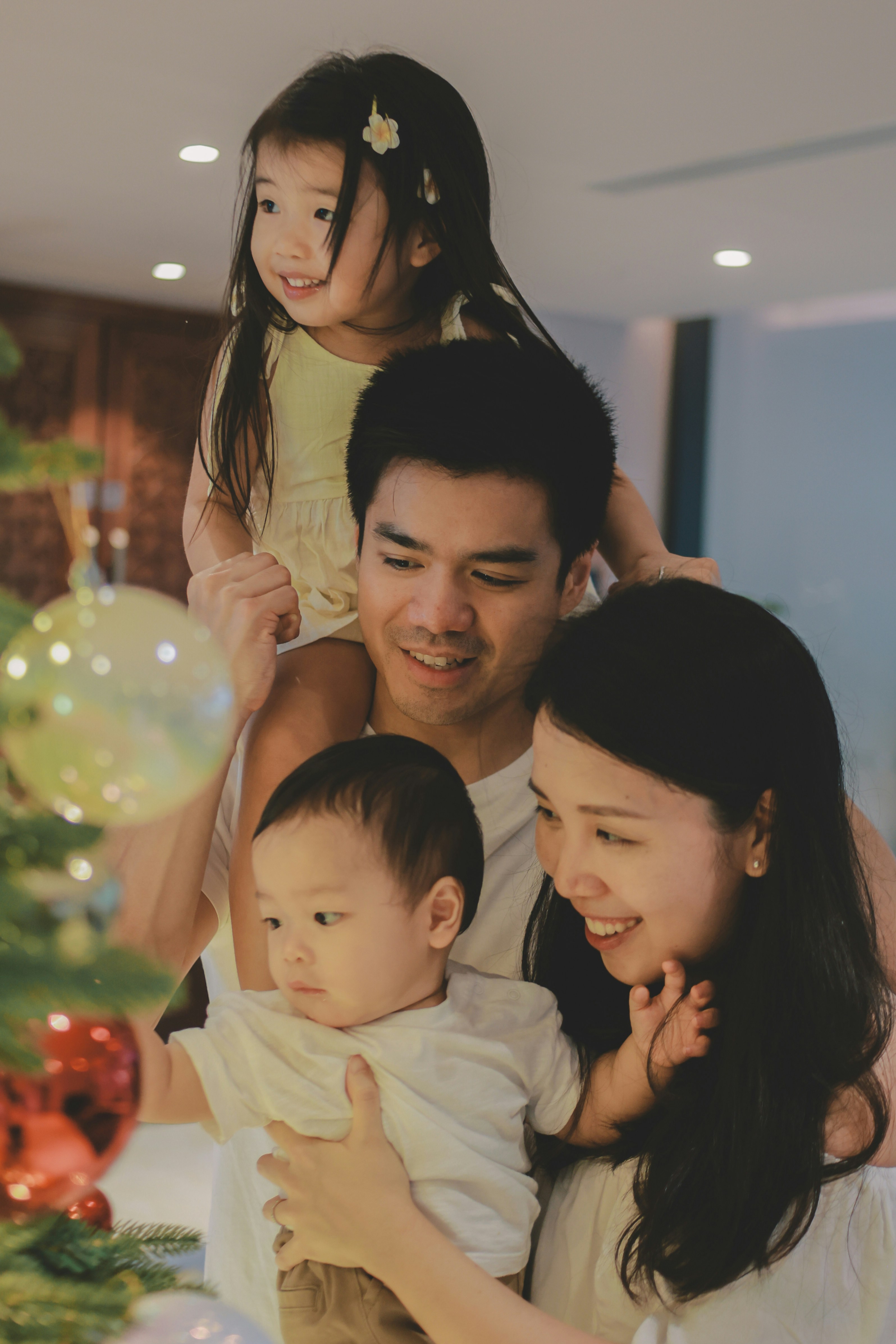 Family Celebration: A Father Lifts Daughter as Parents Guide Baby toward the Glow