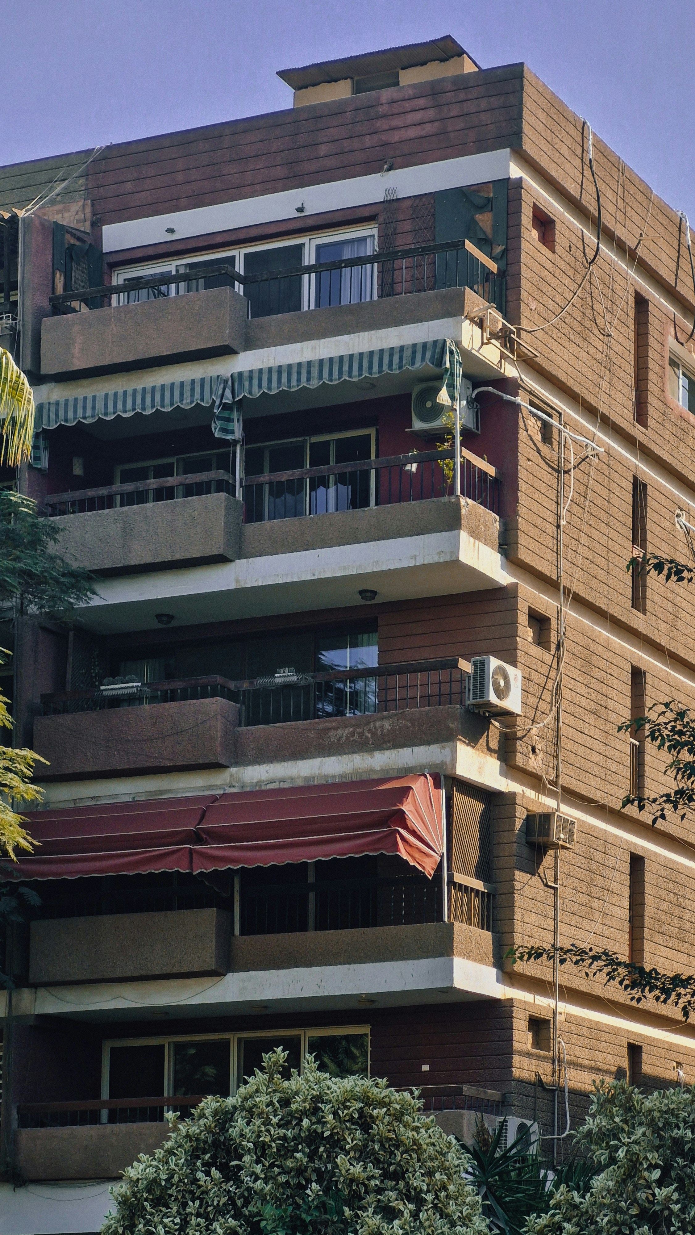 Multi-story building with balconies and awnings.