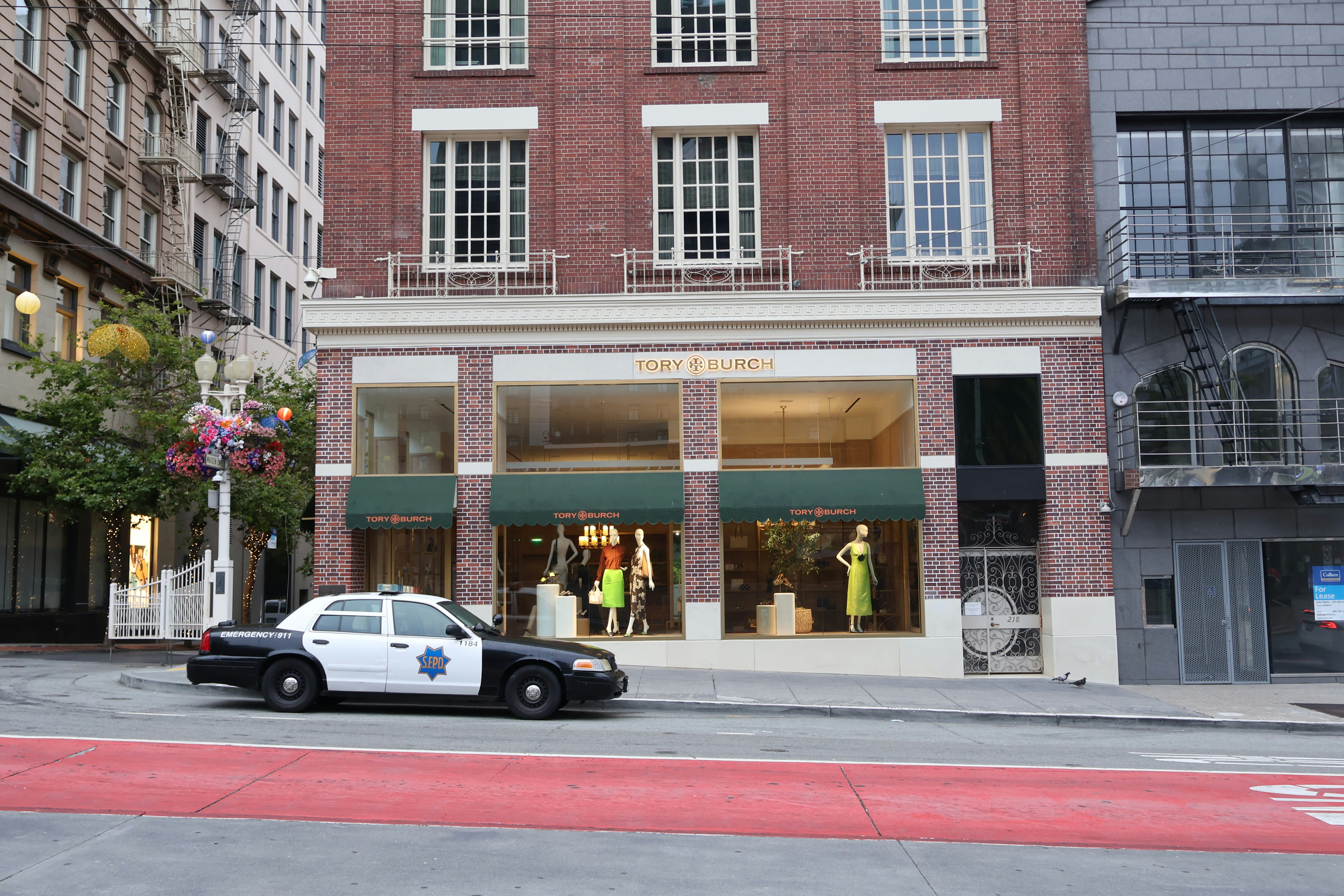 Police car parked outside a store on a city street. photo – Free Retail ...