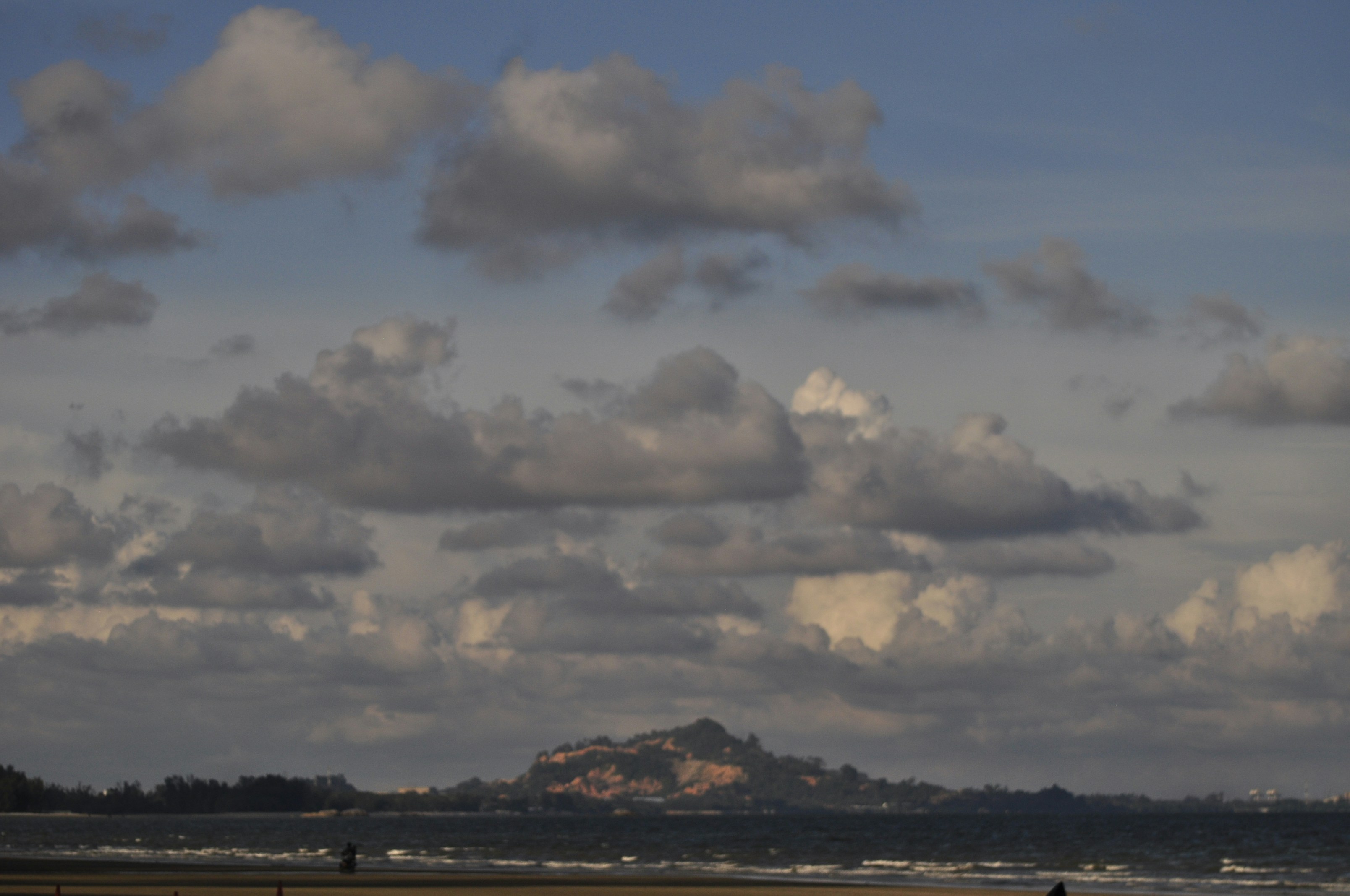 Distant Island Silhouetted by Low-Tide Horizon