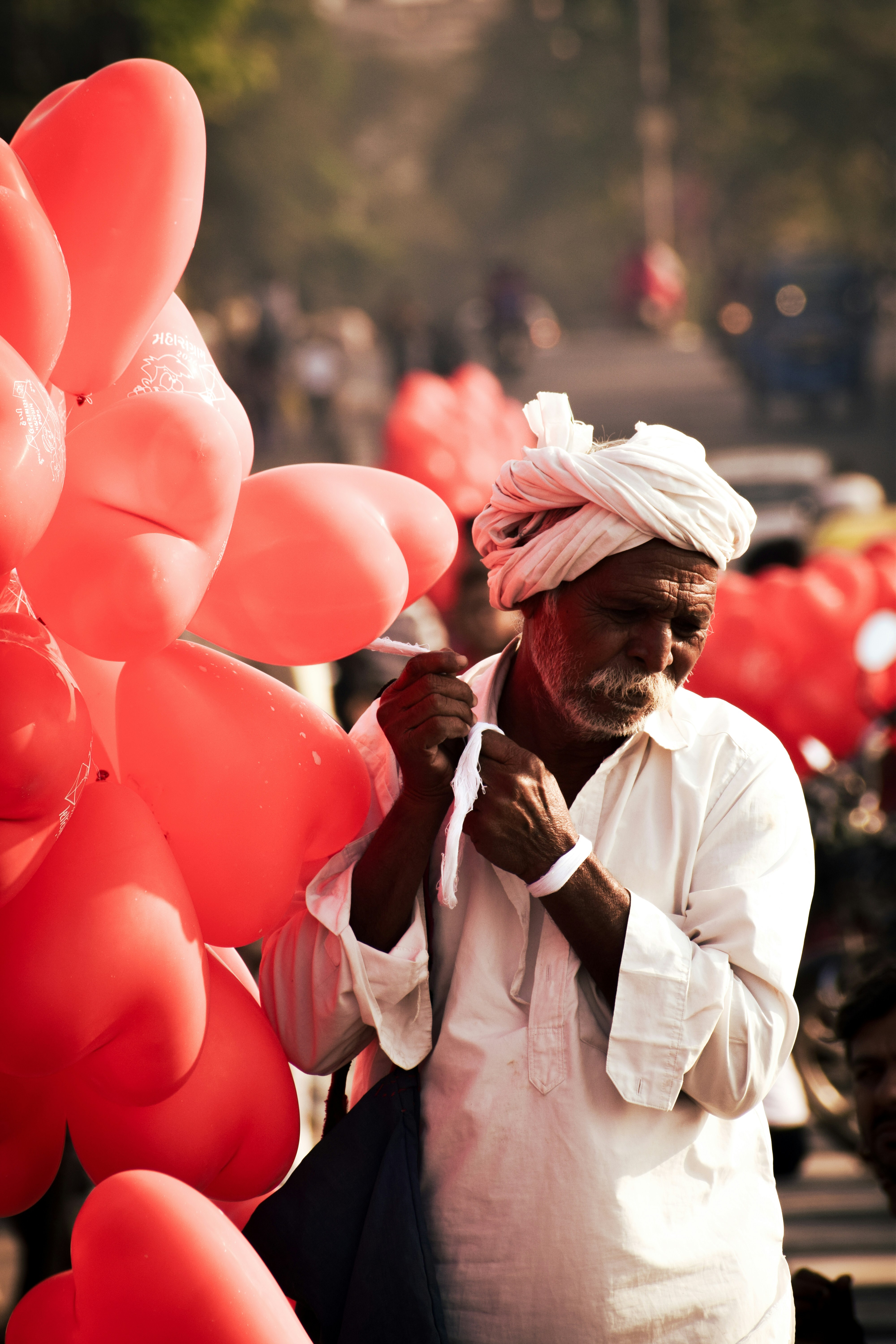Masala of Red: A Balloon Vendor in a Sunlit Parade