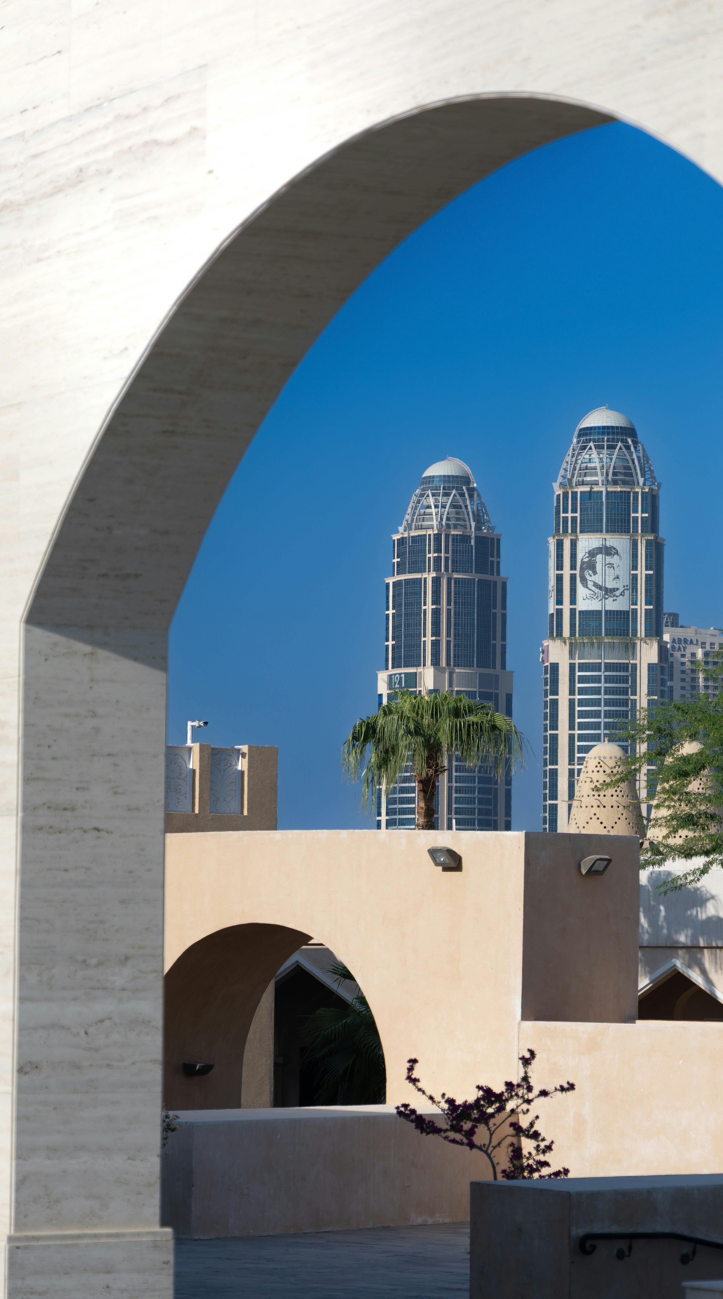 Archway Frame: City Towers Rise Beyond a Desert Courtyard