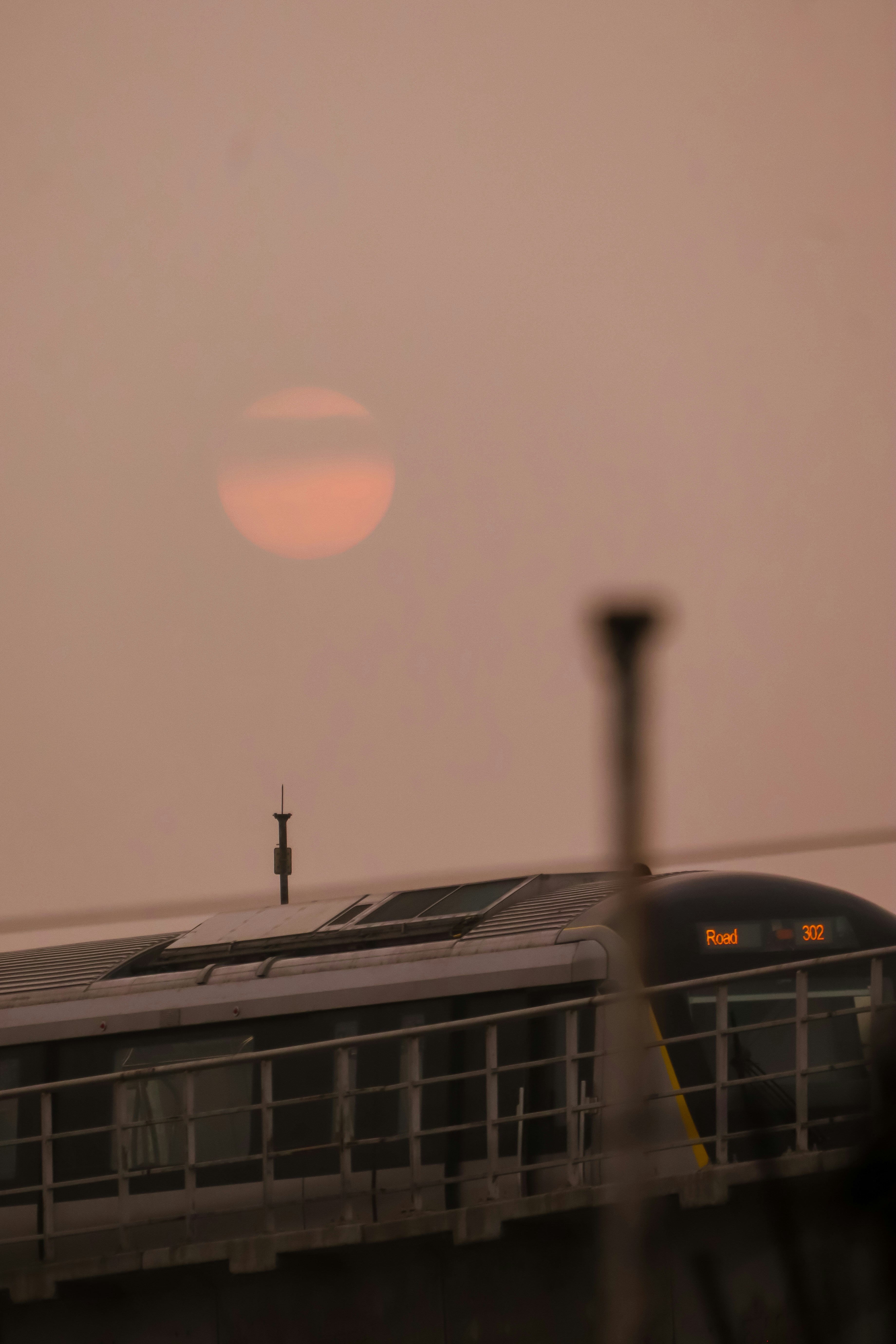 Sunset commuter: train car silhouette beneath a fading sun