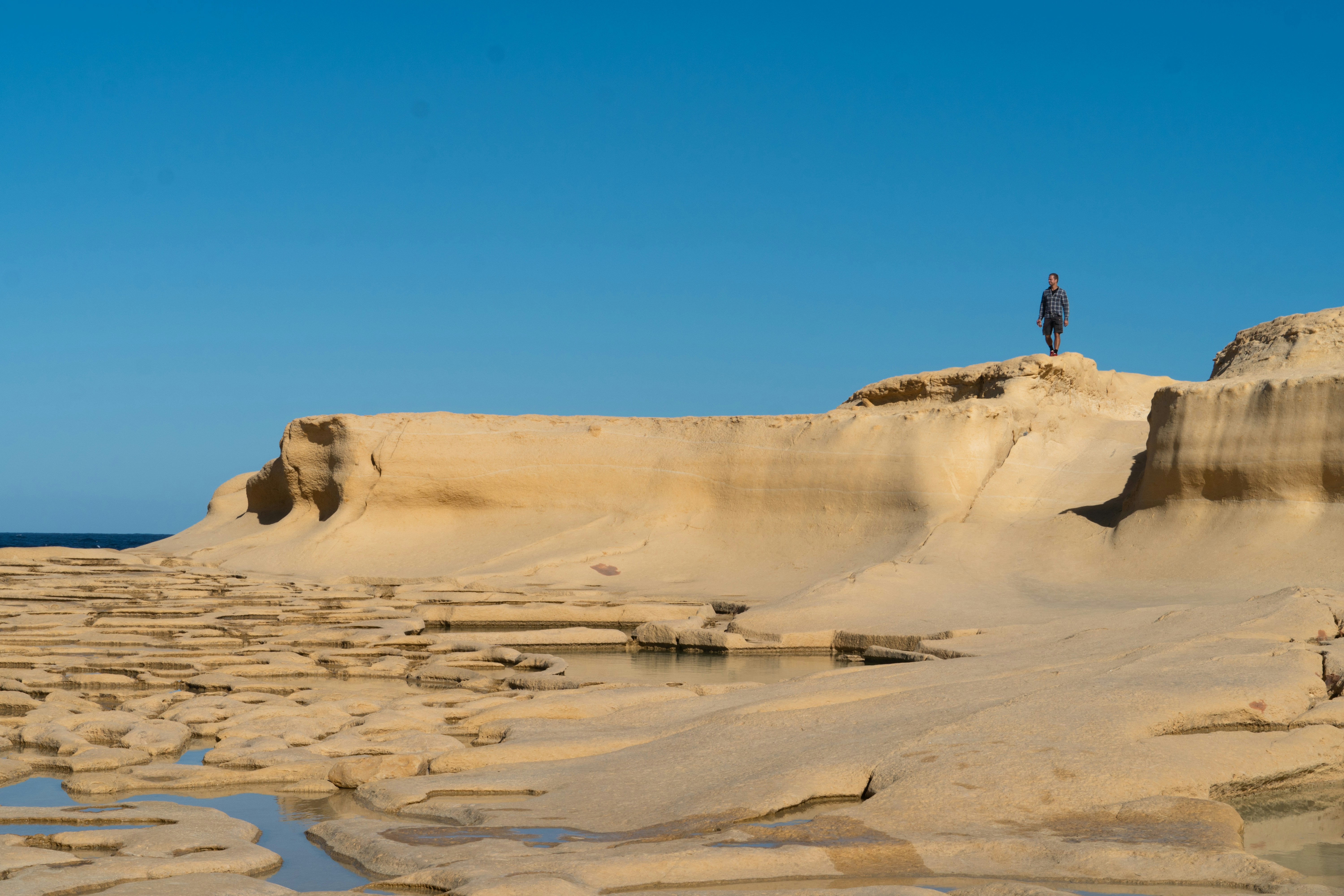 Top of the Cliff: A solitary figure overlooking the sea-etched rockscape