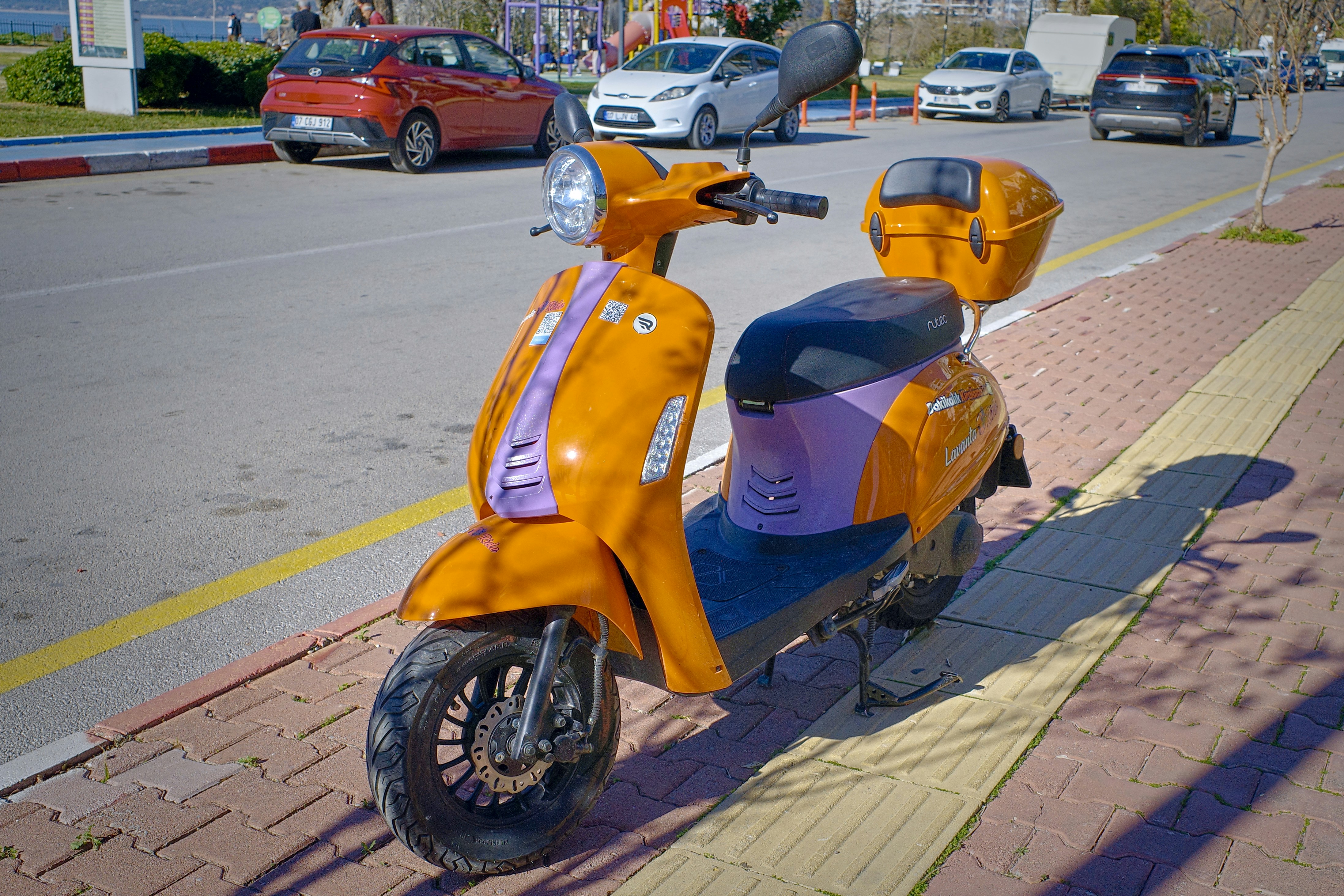 Sunlit Orange Scooter: A Quiet Street Moment