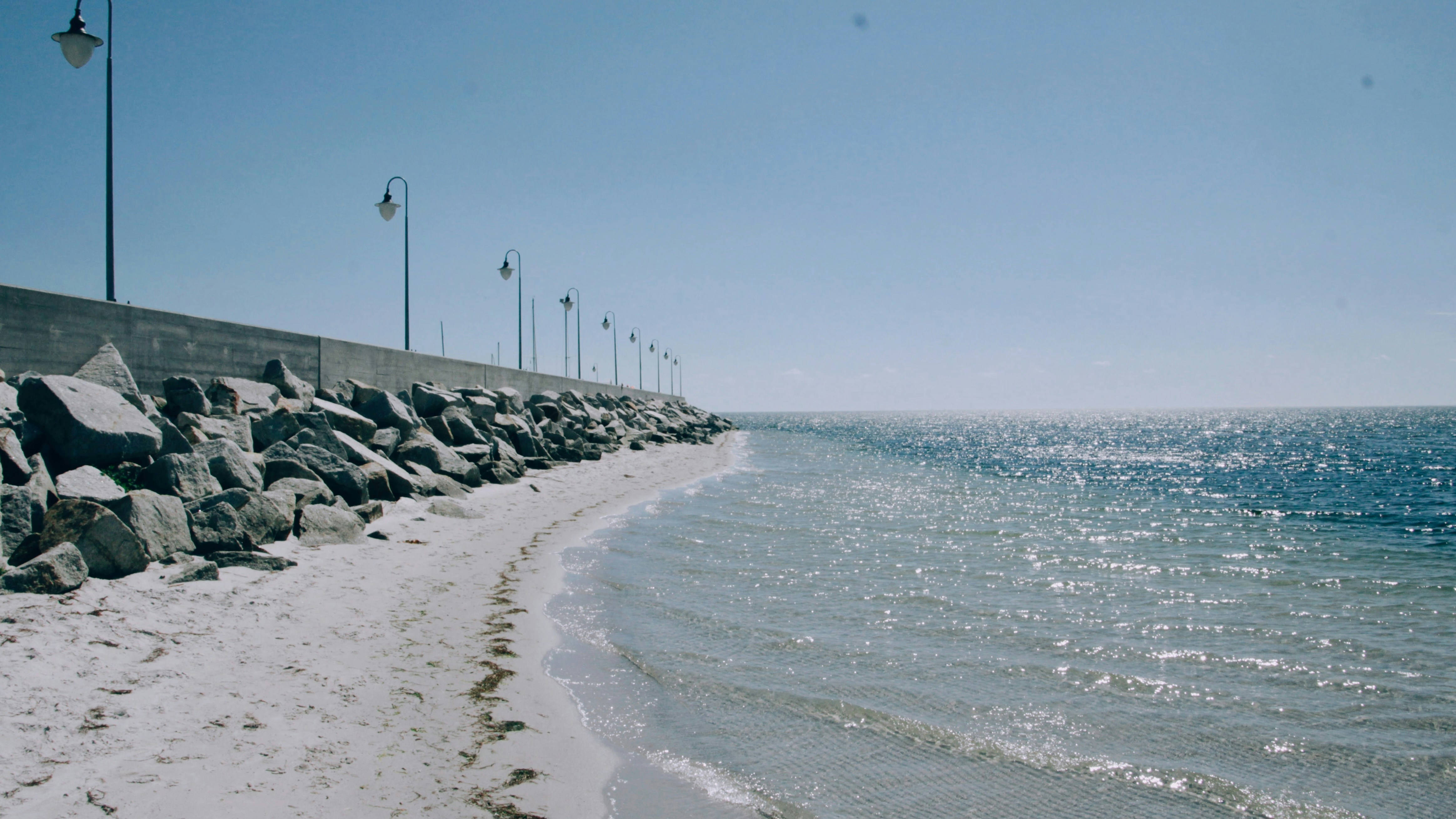 Sunlit Break: A Quiet Seaside Promenade Along the Rocky Pier