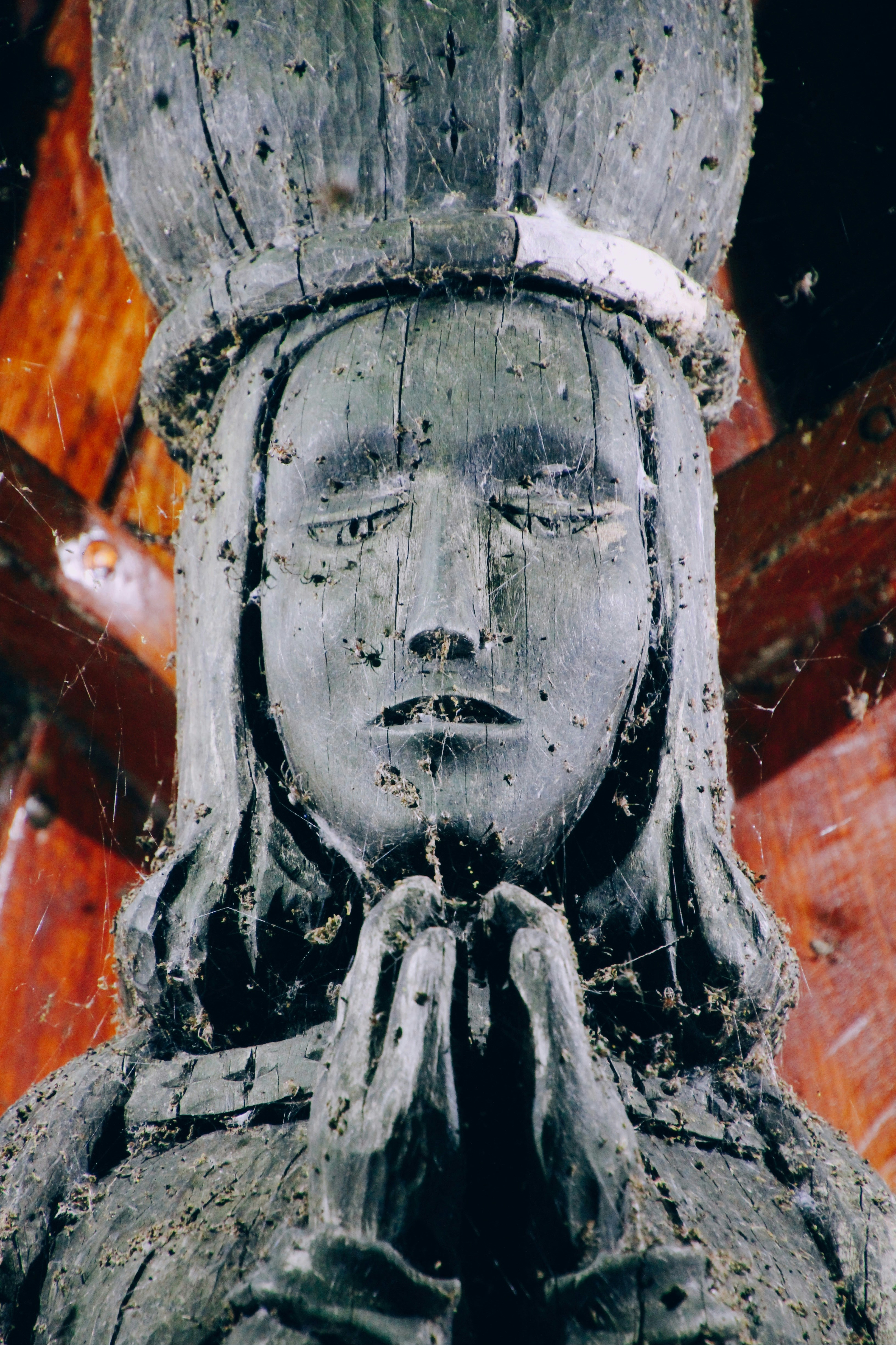 Weathered Guardian: A Stoic Carved Figure Frozen in Time
