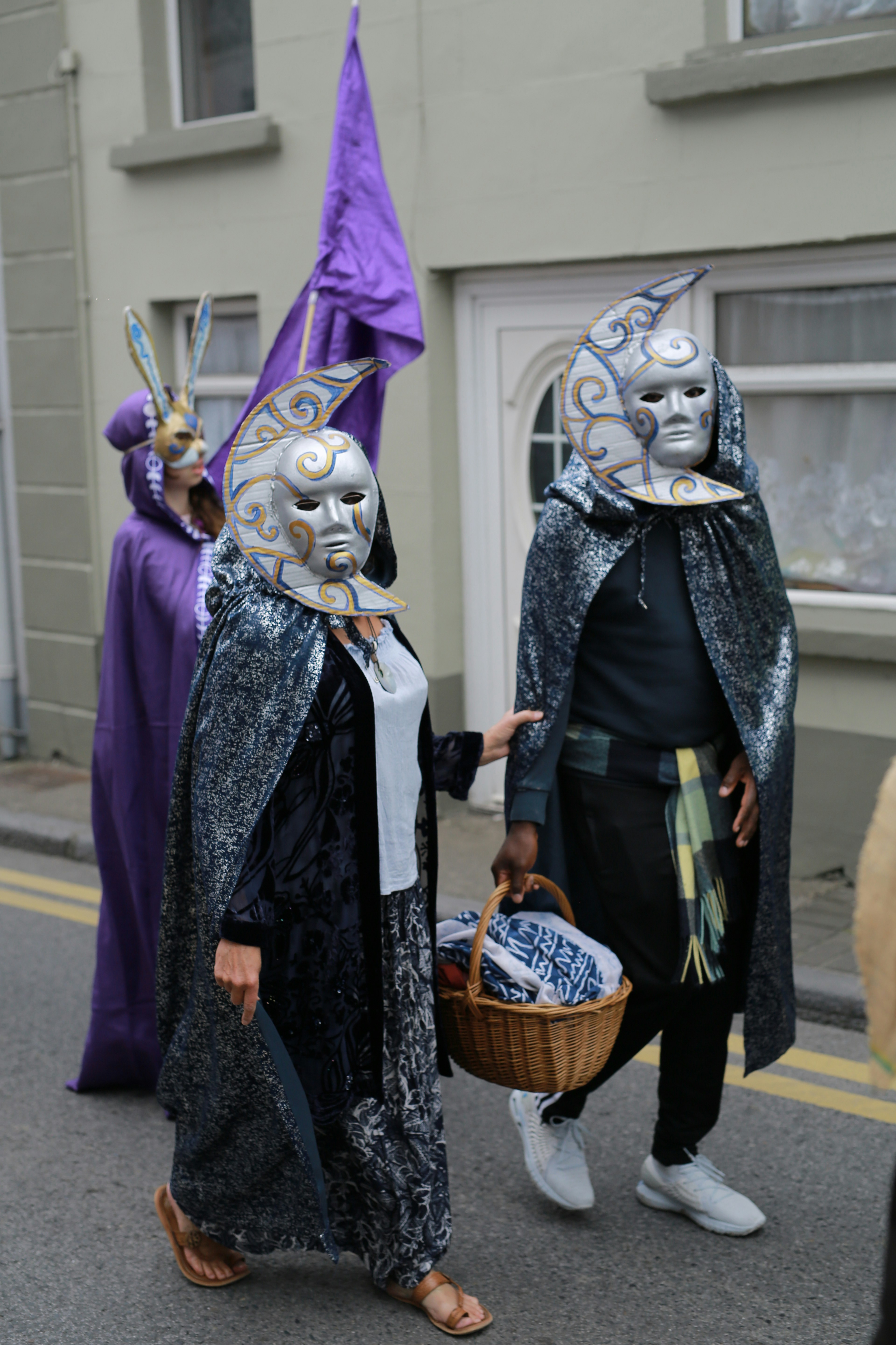 Masked Parade: Cloaked Figures in Ornate Heraldic Hats