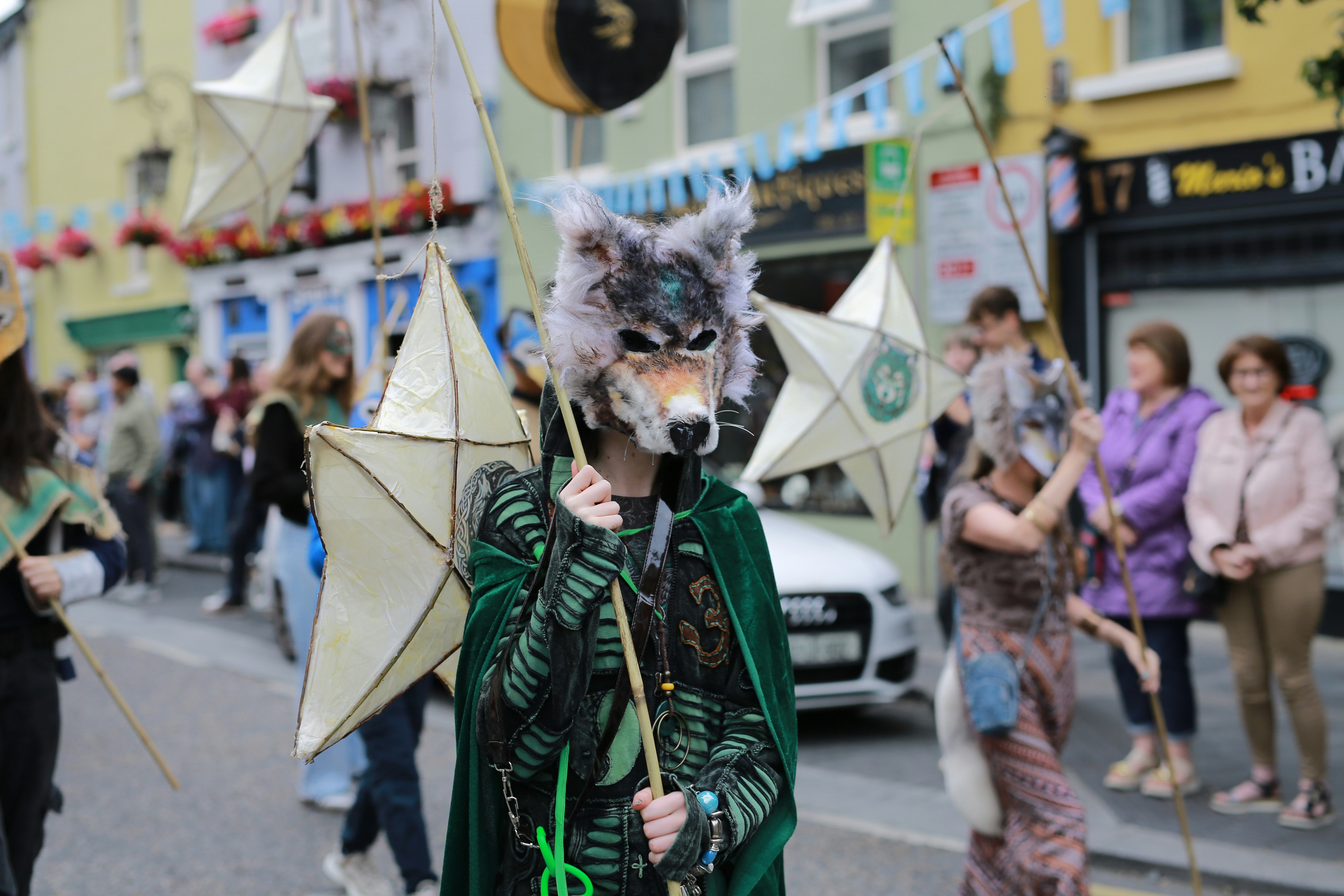 Persona con máscara de lobo y capa verde en el festival foto – Imagen ...