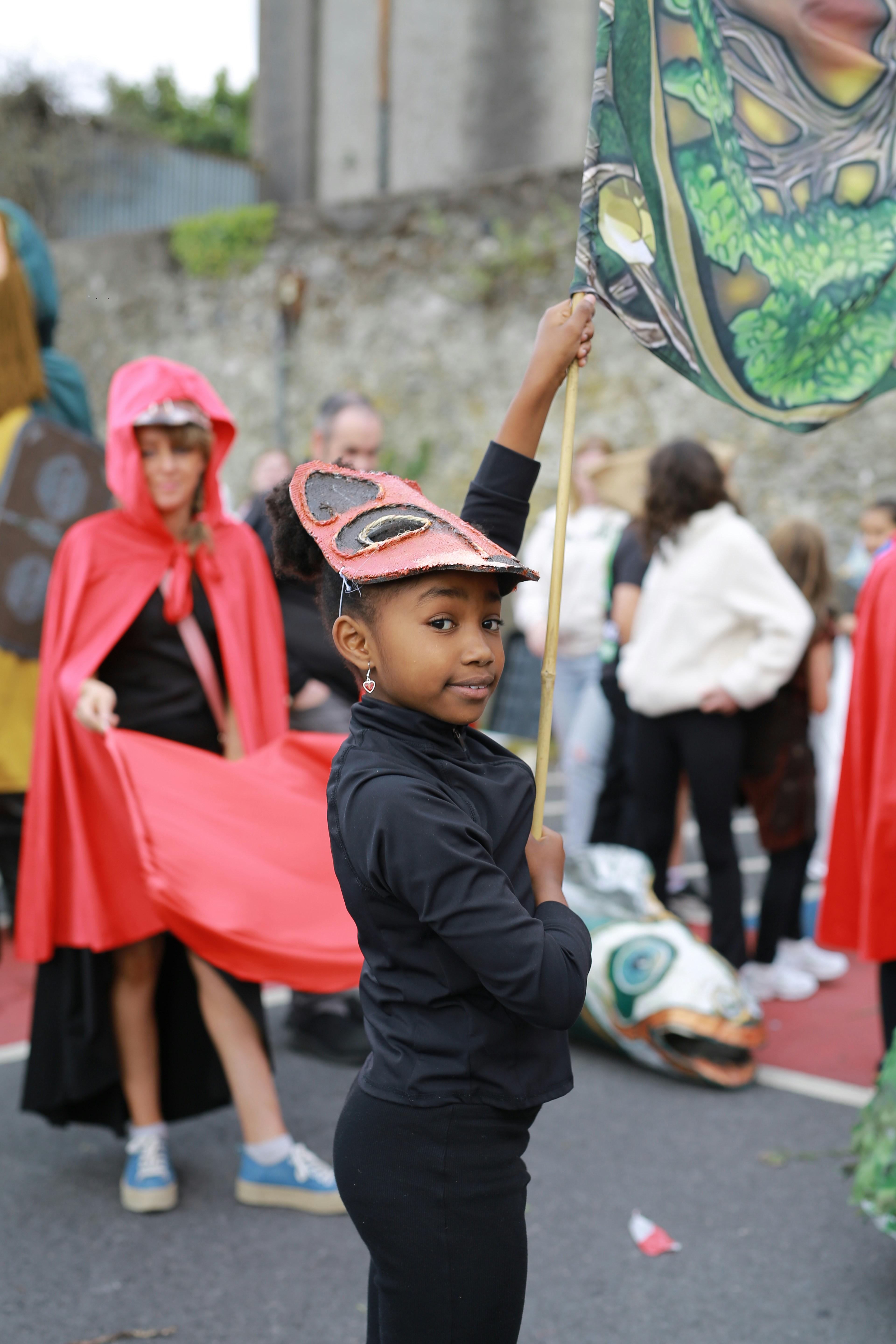 Child with Dragon Banner Leads a Colorful Parade