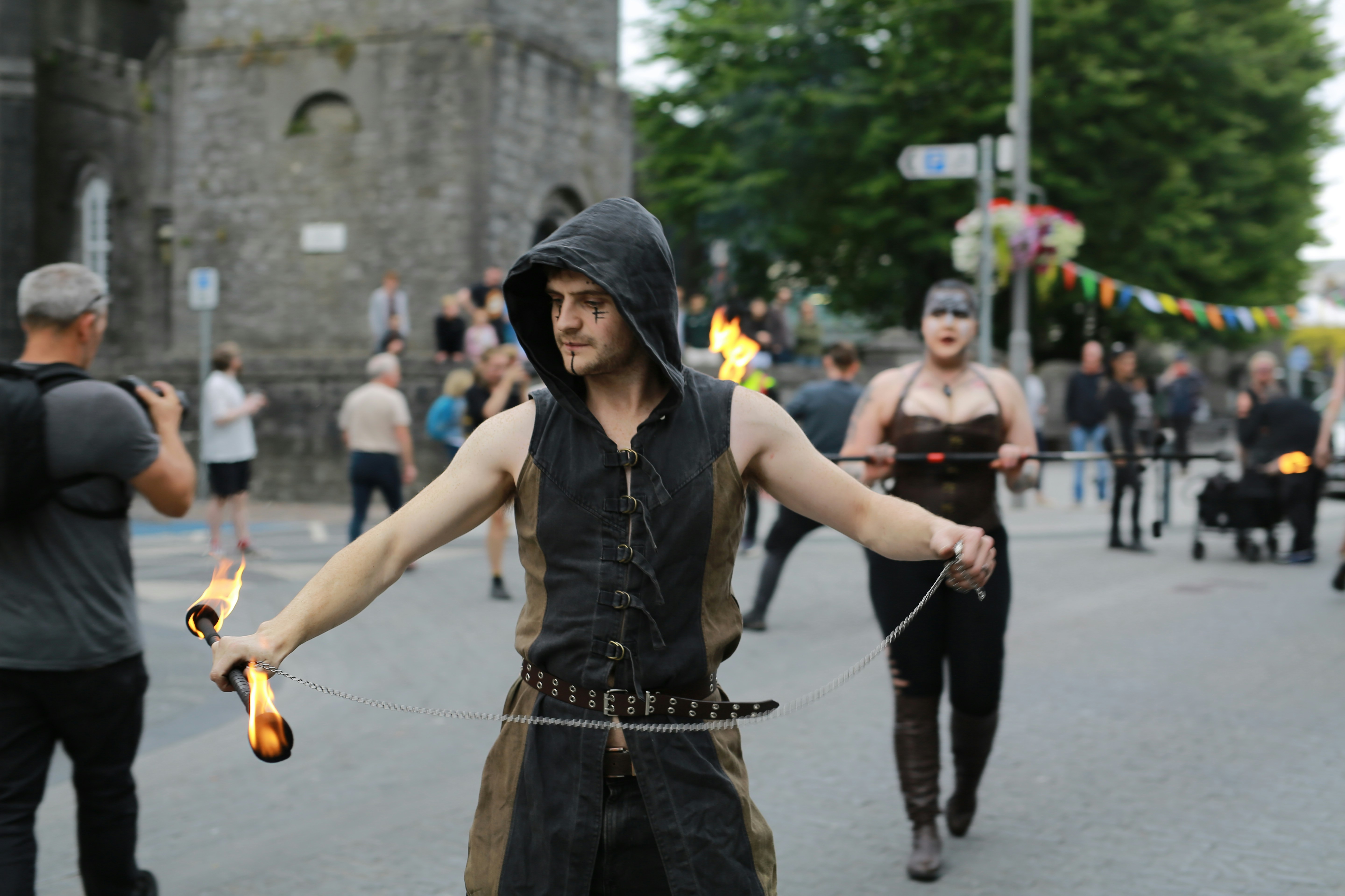 Fiery street performance: the cloak-wearing duelist with torches in a medieval-style parade