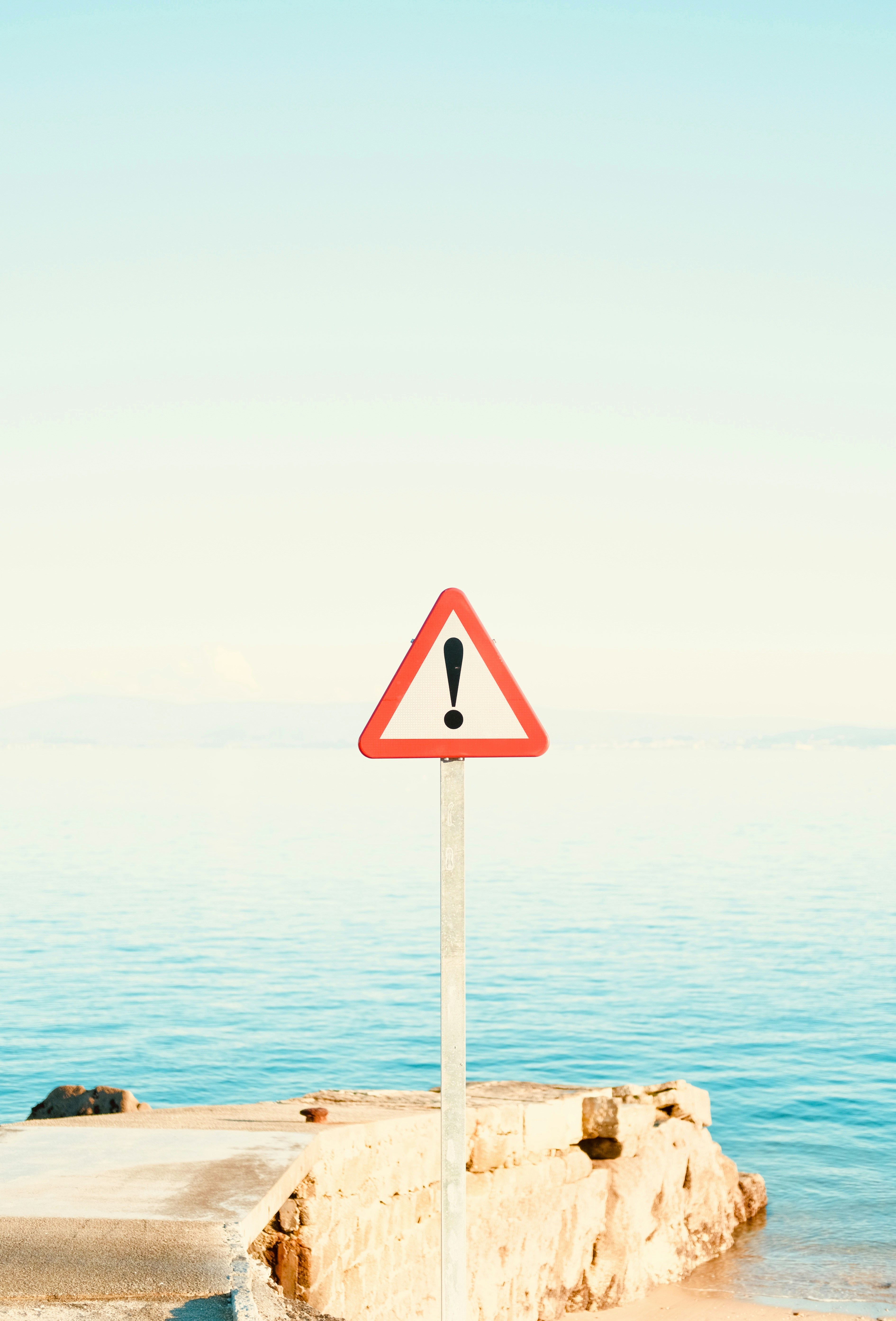 Warning Sign at the Quiet Edge of the Sea