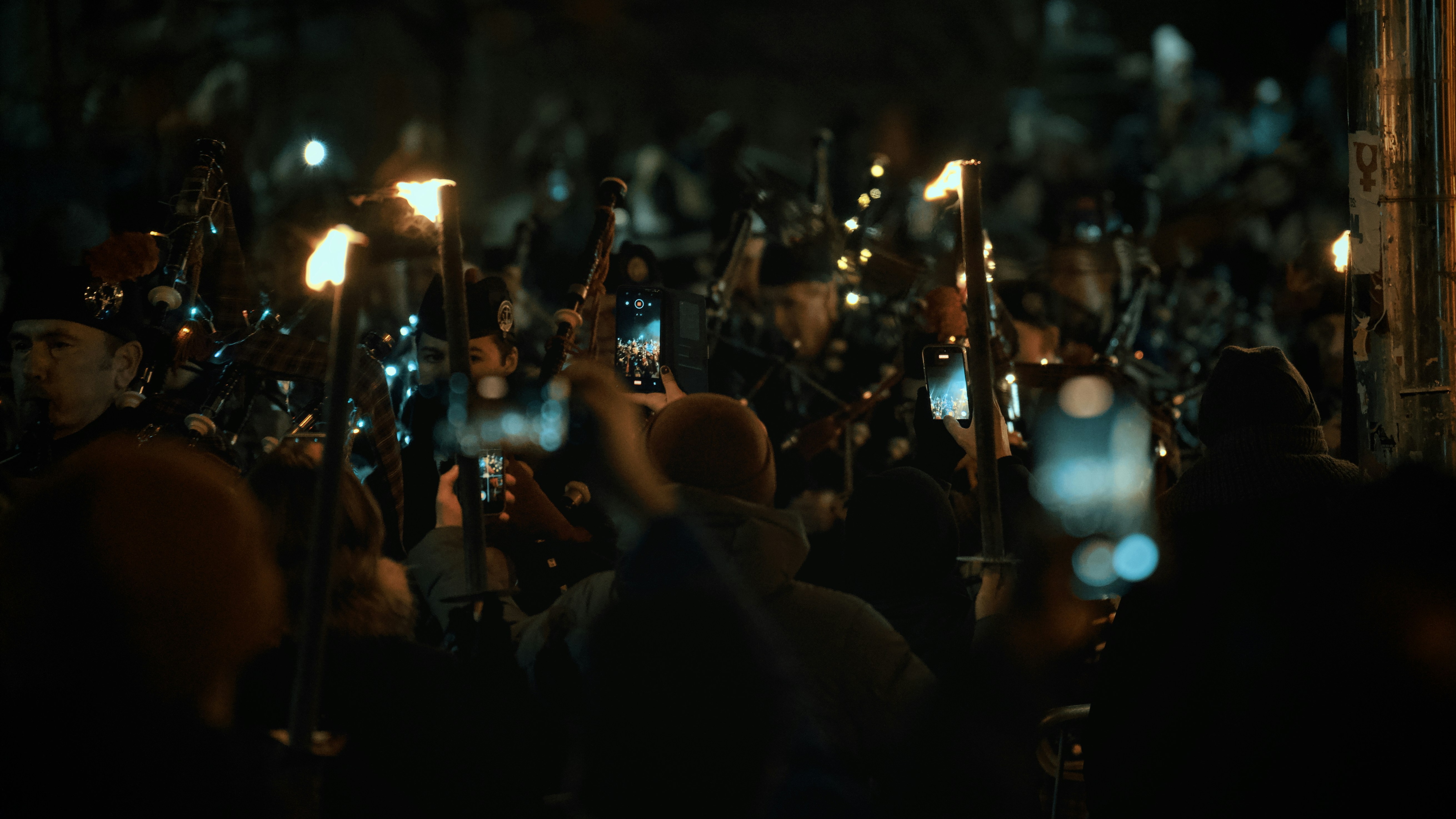 Torchlit Assembly: Faces Lit by Smartphone Glows in a Night Rally