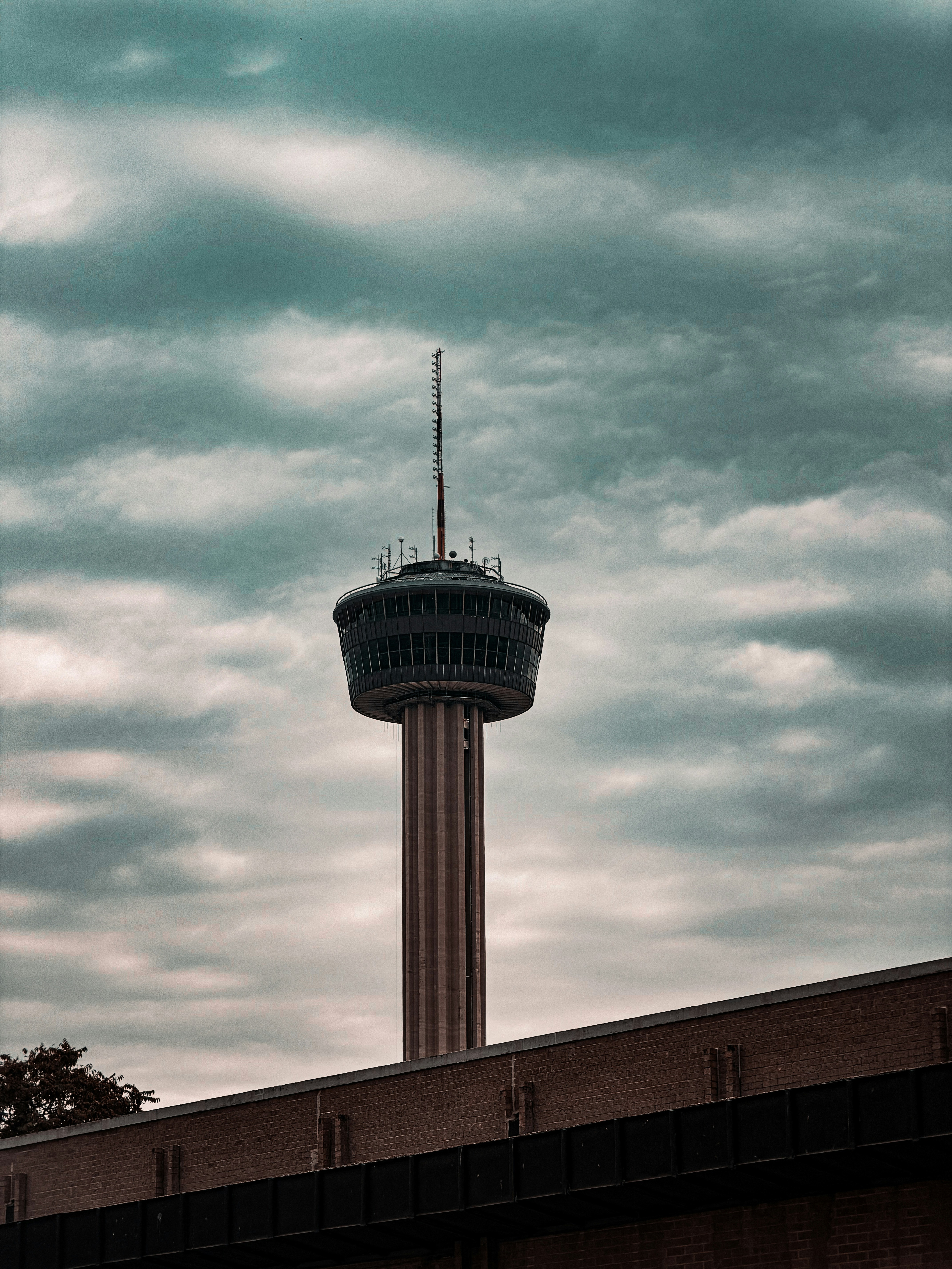 Television Tower Pierces a Studio Sky Above an Industrial Roof