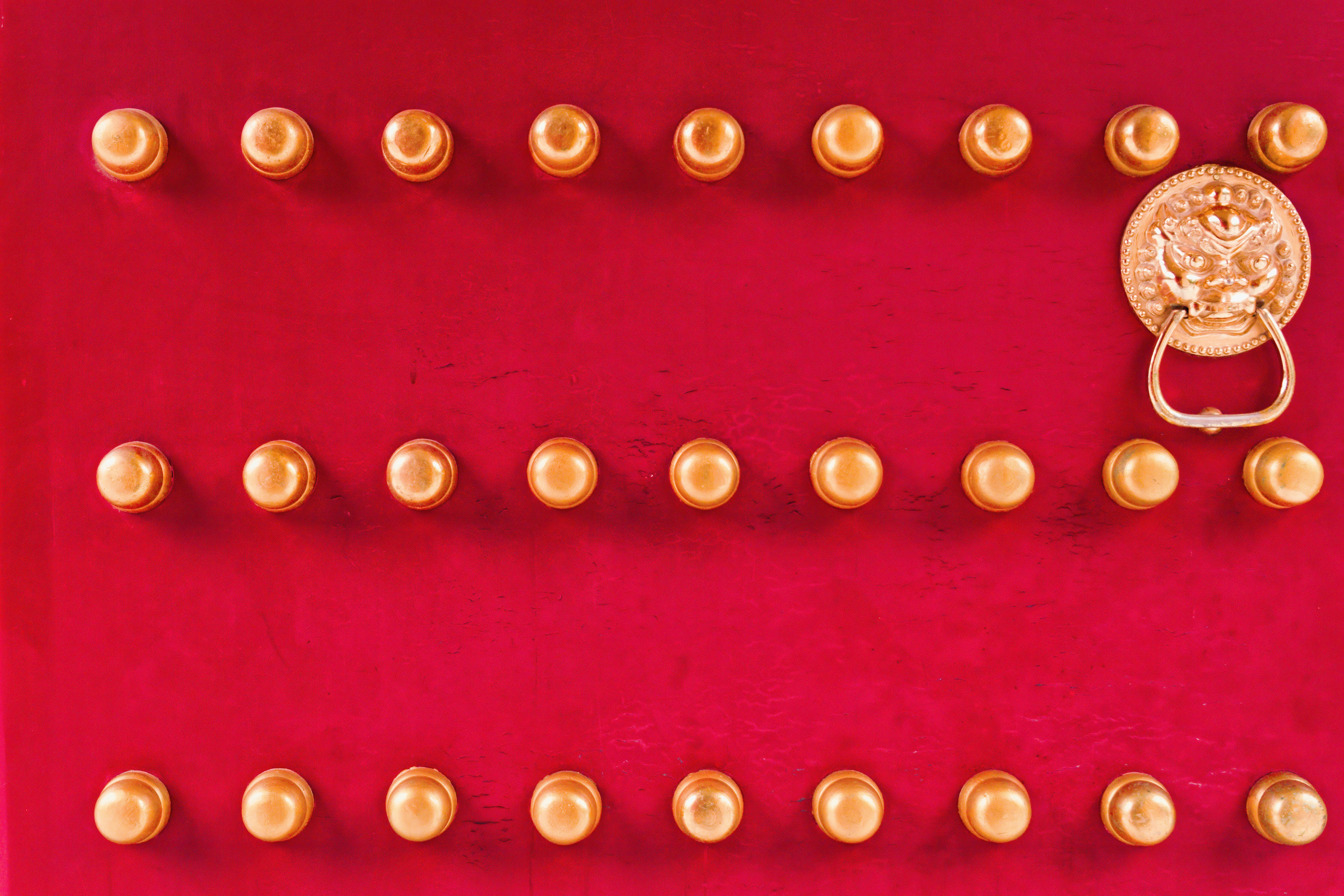 Studded Red: A Close-Up of Craft and Hardware on Velvet Surface