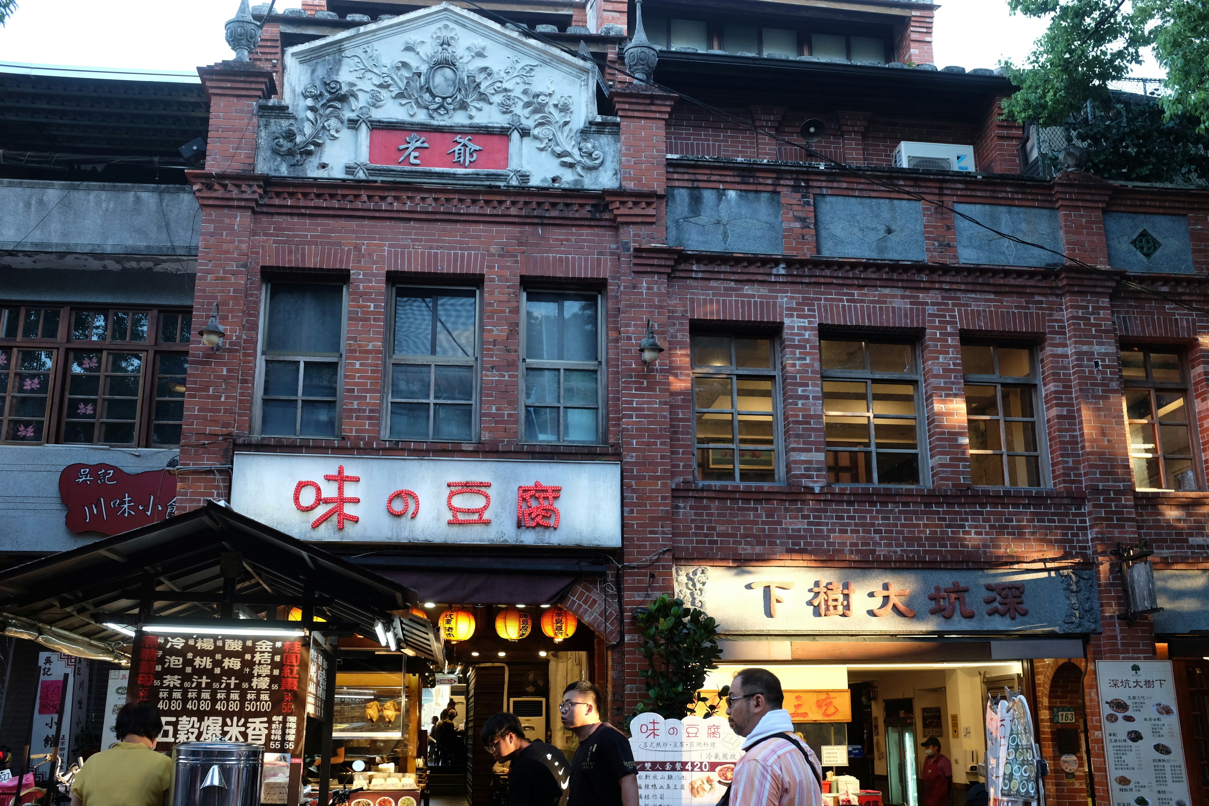 Brick Facades and Neon: A Lively Shopfront Corridor at Twilight