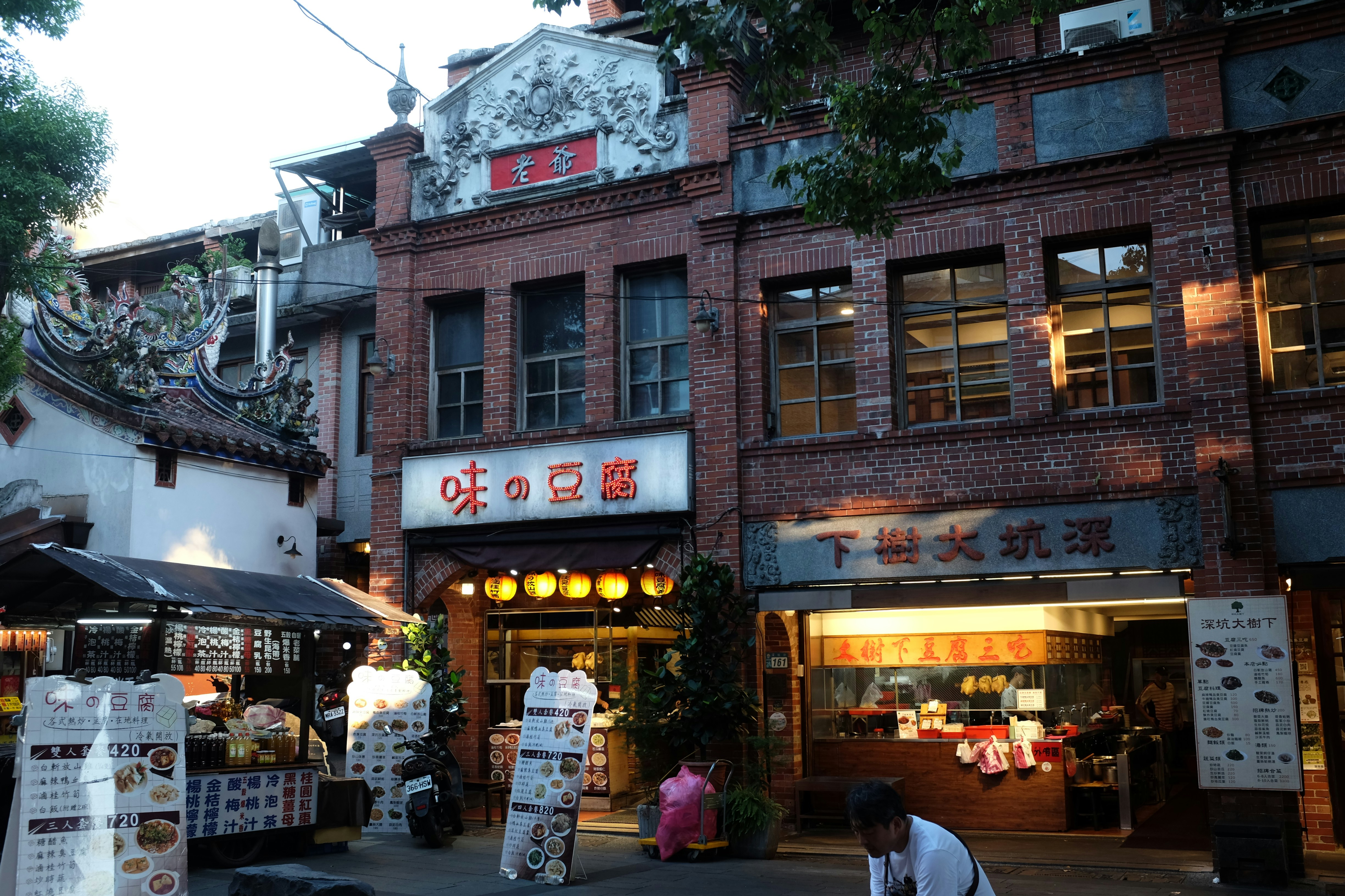 Lantern-lit storefronts on a brick alley reveal a quiet street of old-town charm