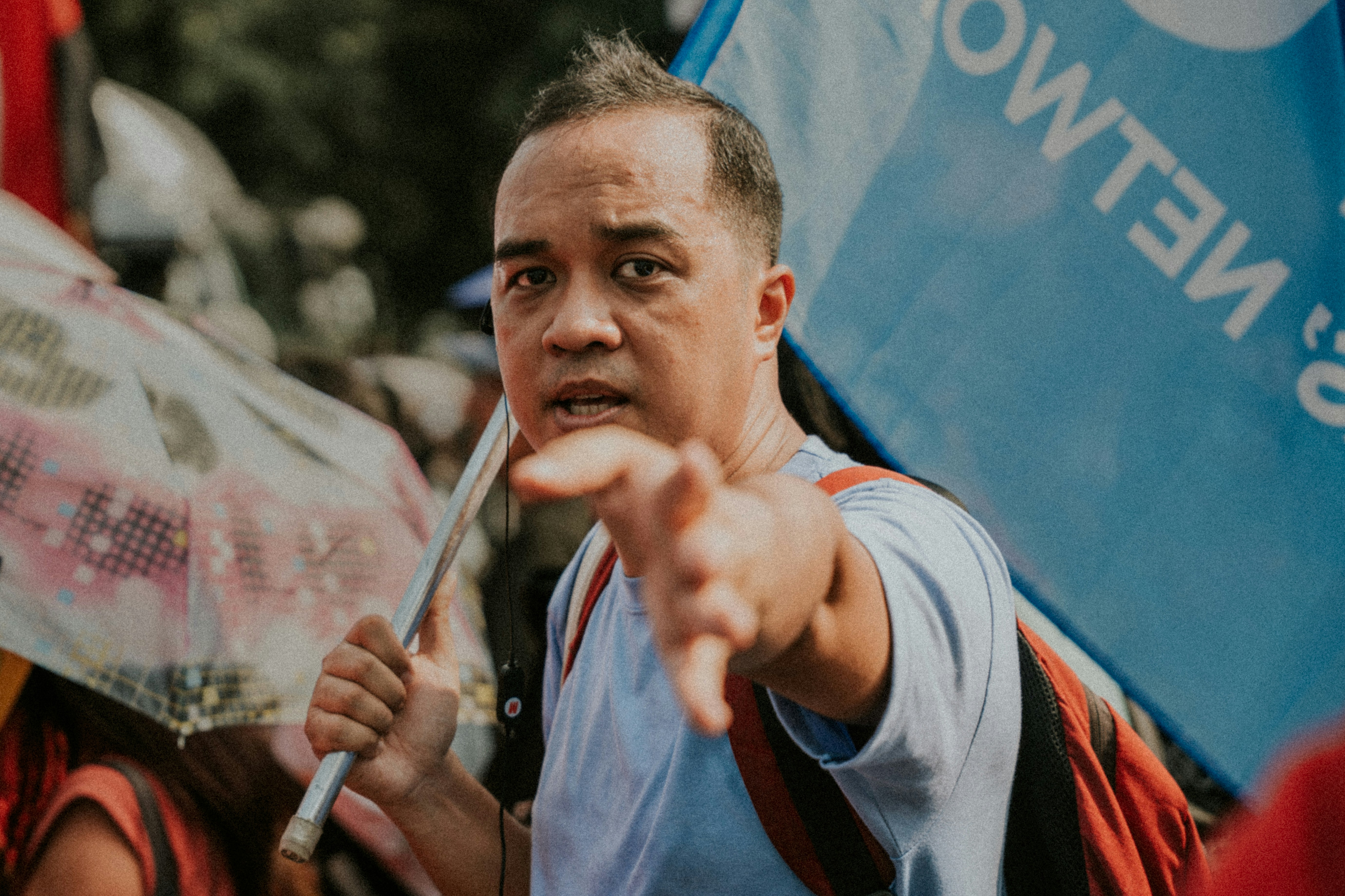 Man reaching out with a flag behind him. photo – Free Crowd Image on ...