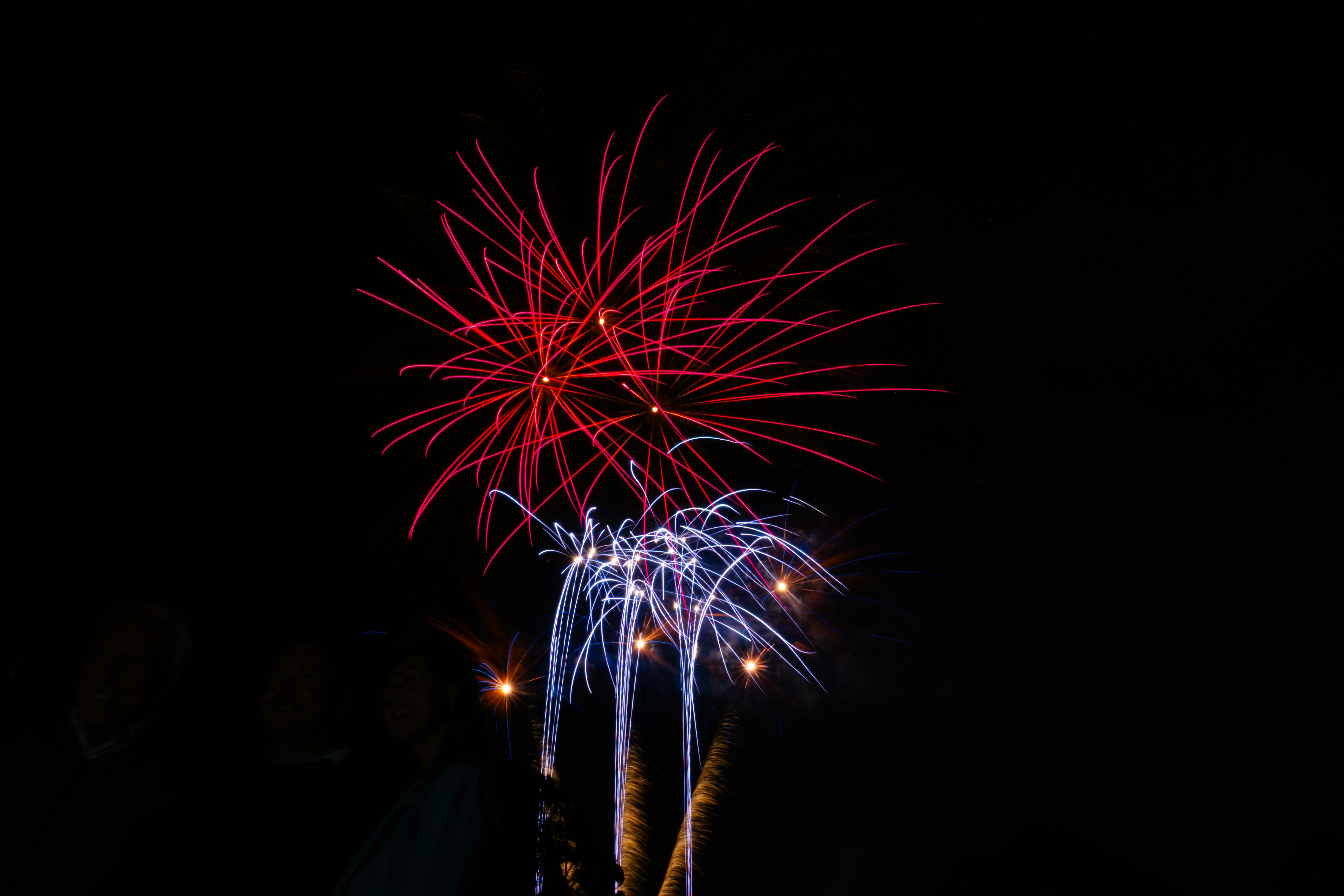 Red and White Fireburst Above a Dark Night Crowd