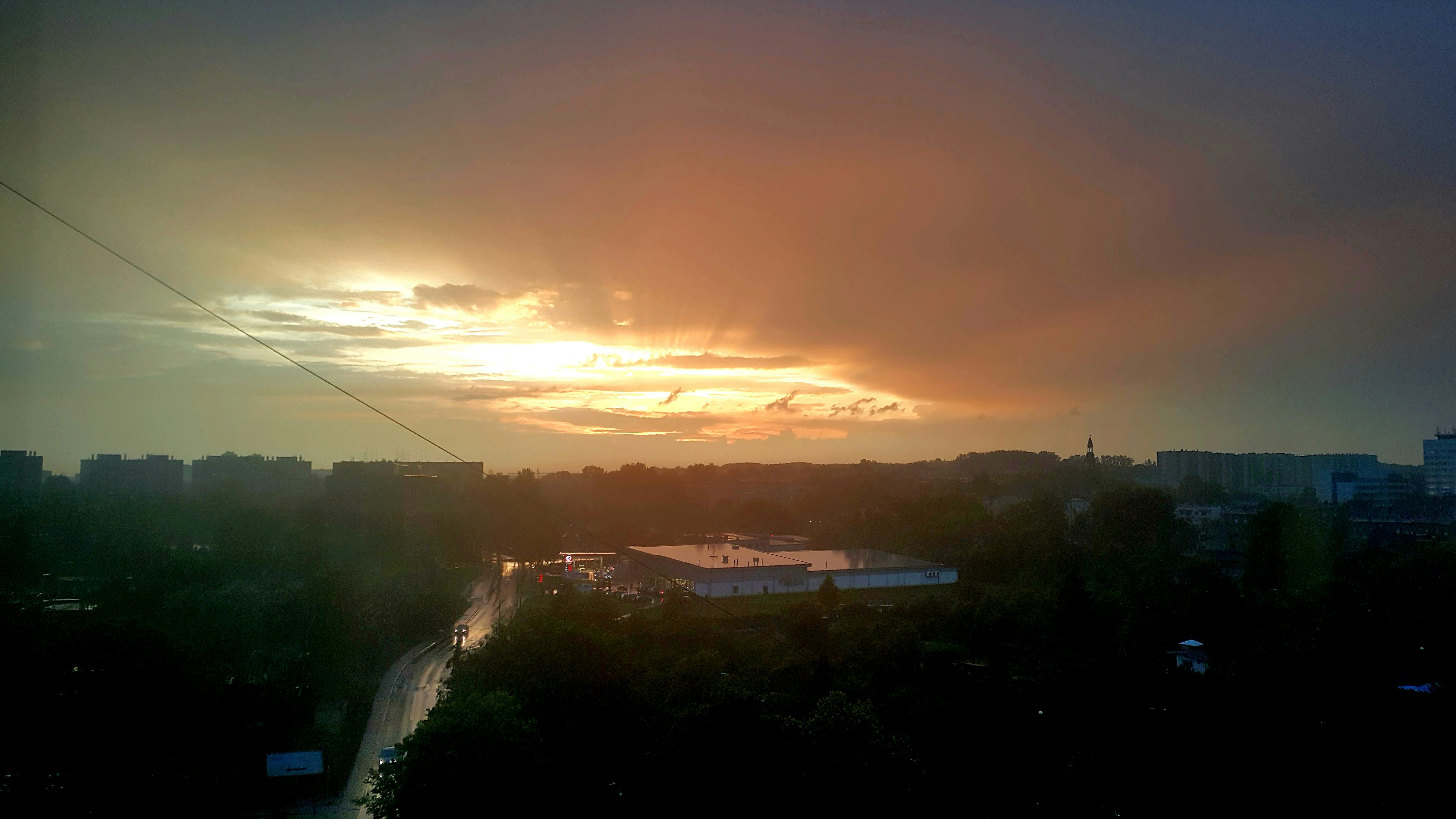 Sunset over a dark cityscape with rain streaks