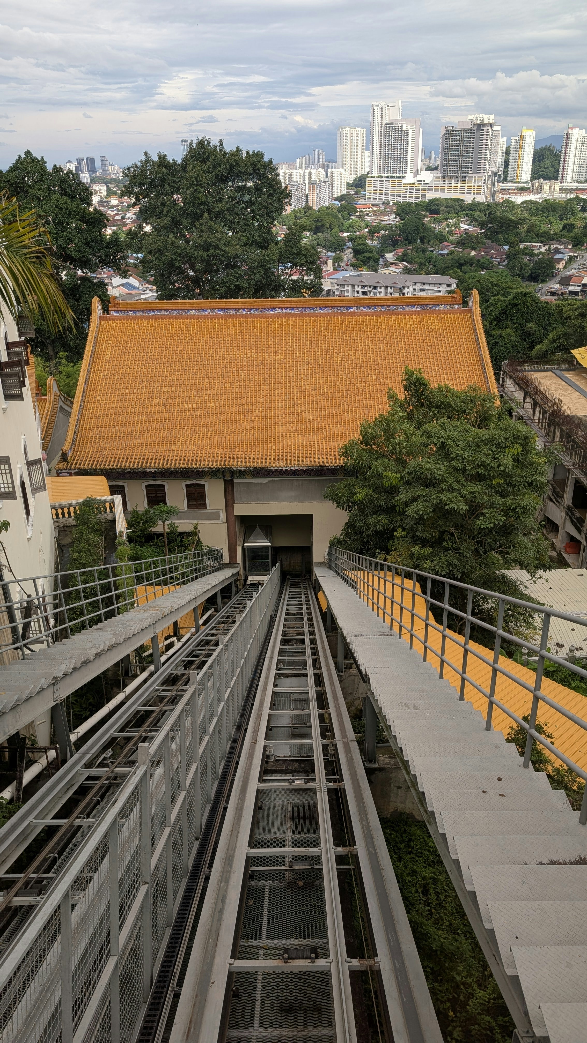 Funicular railway tracks leading towards a building with orange roof.