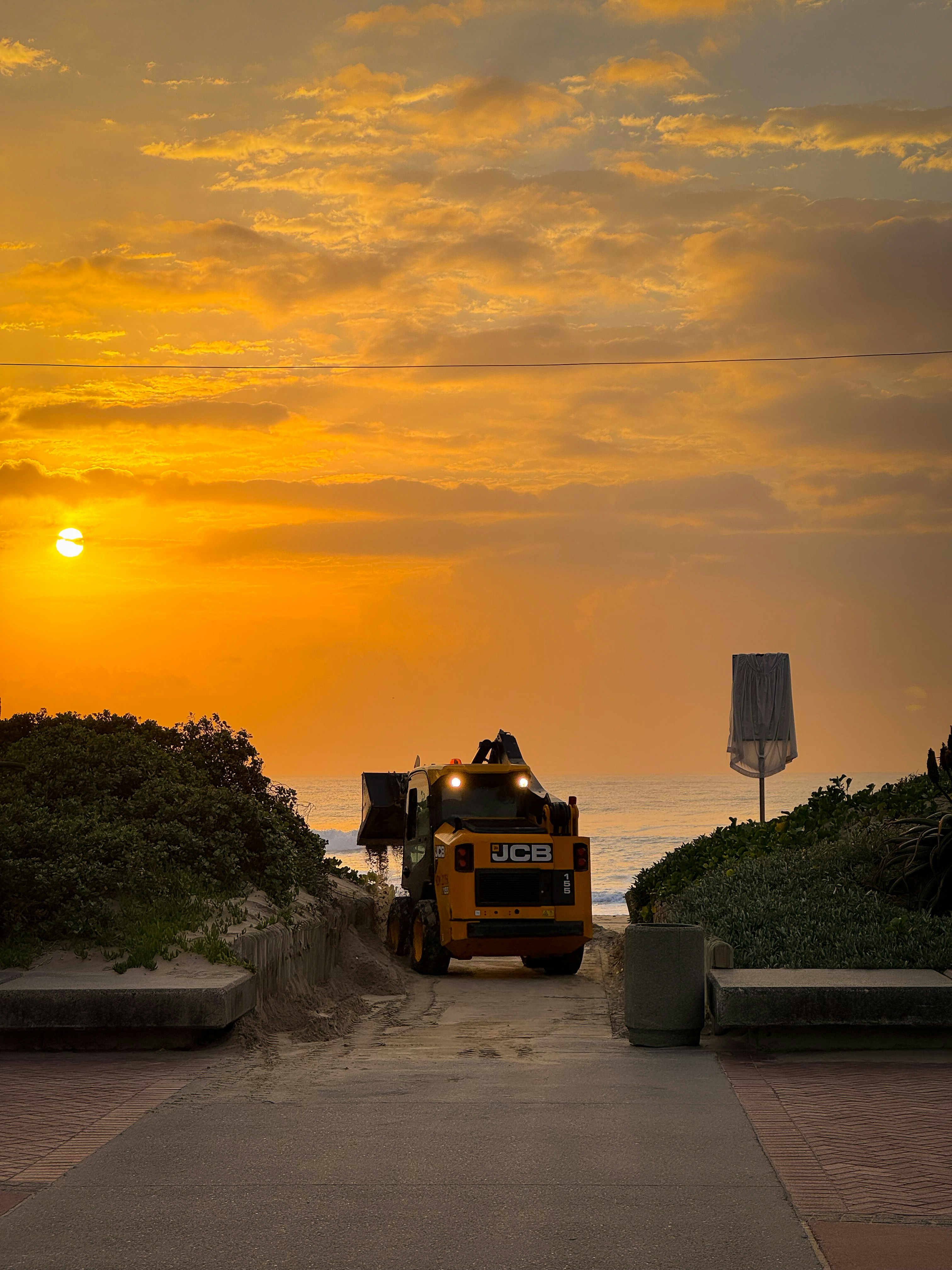 Sunlit Path to the Water: A JCB at Dusk