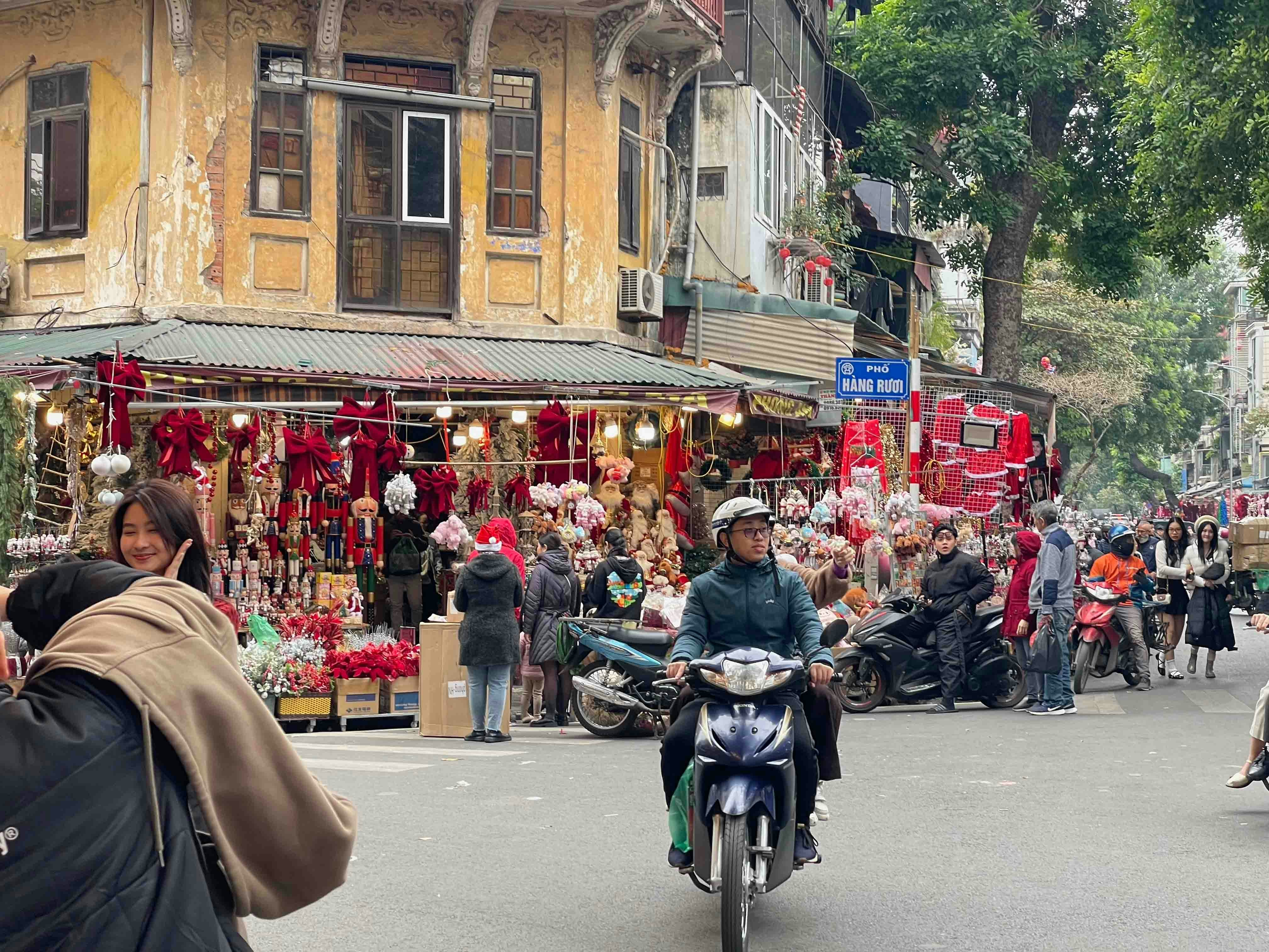 Bustling Hanoi Street shopfronts and scooter traffic