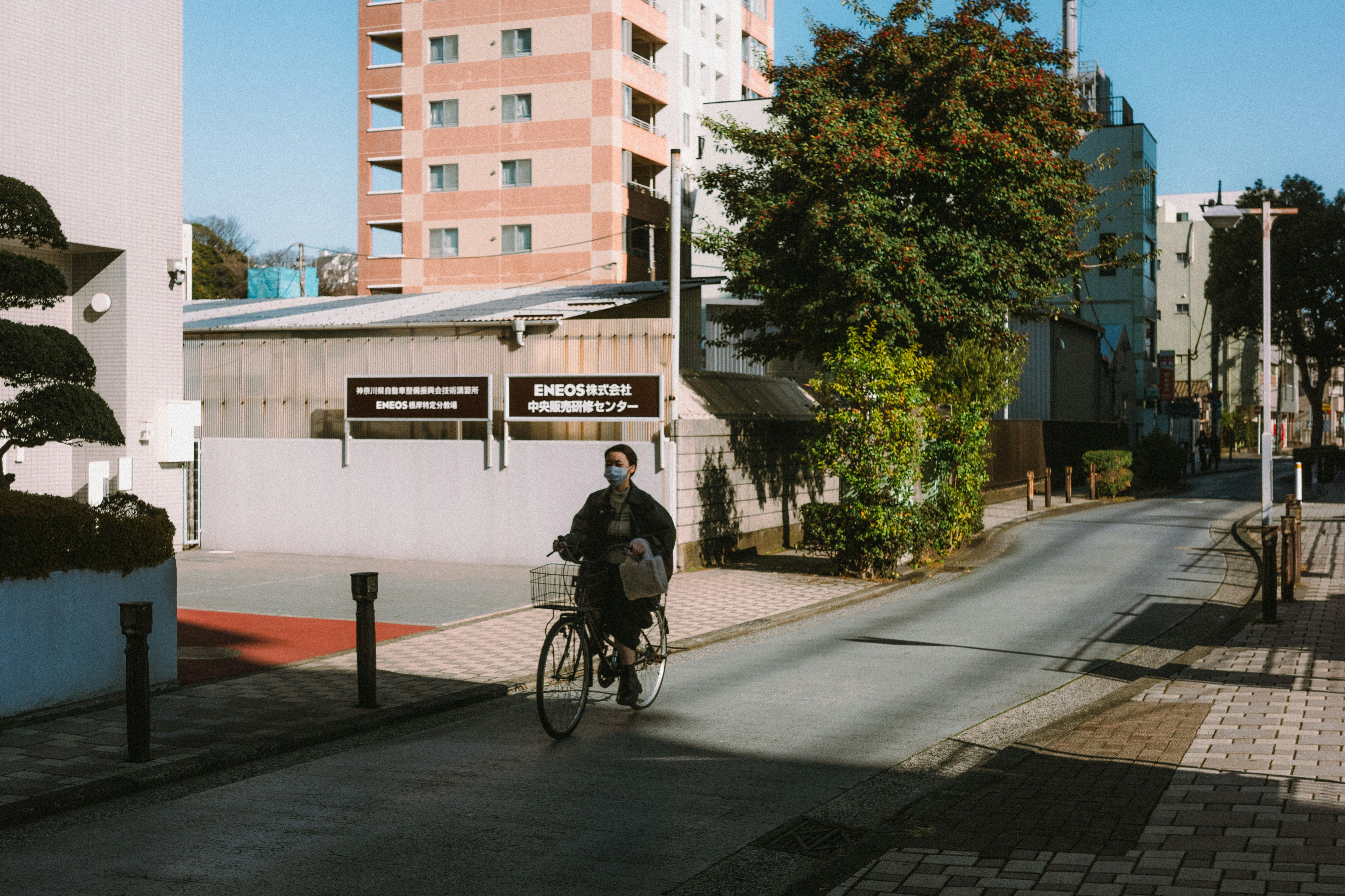 Cyclist on a Quiet Urban Street Near a Pink-Highrise