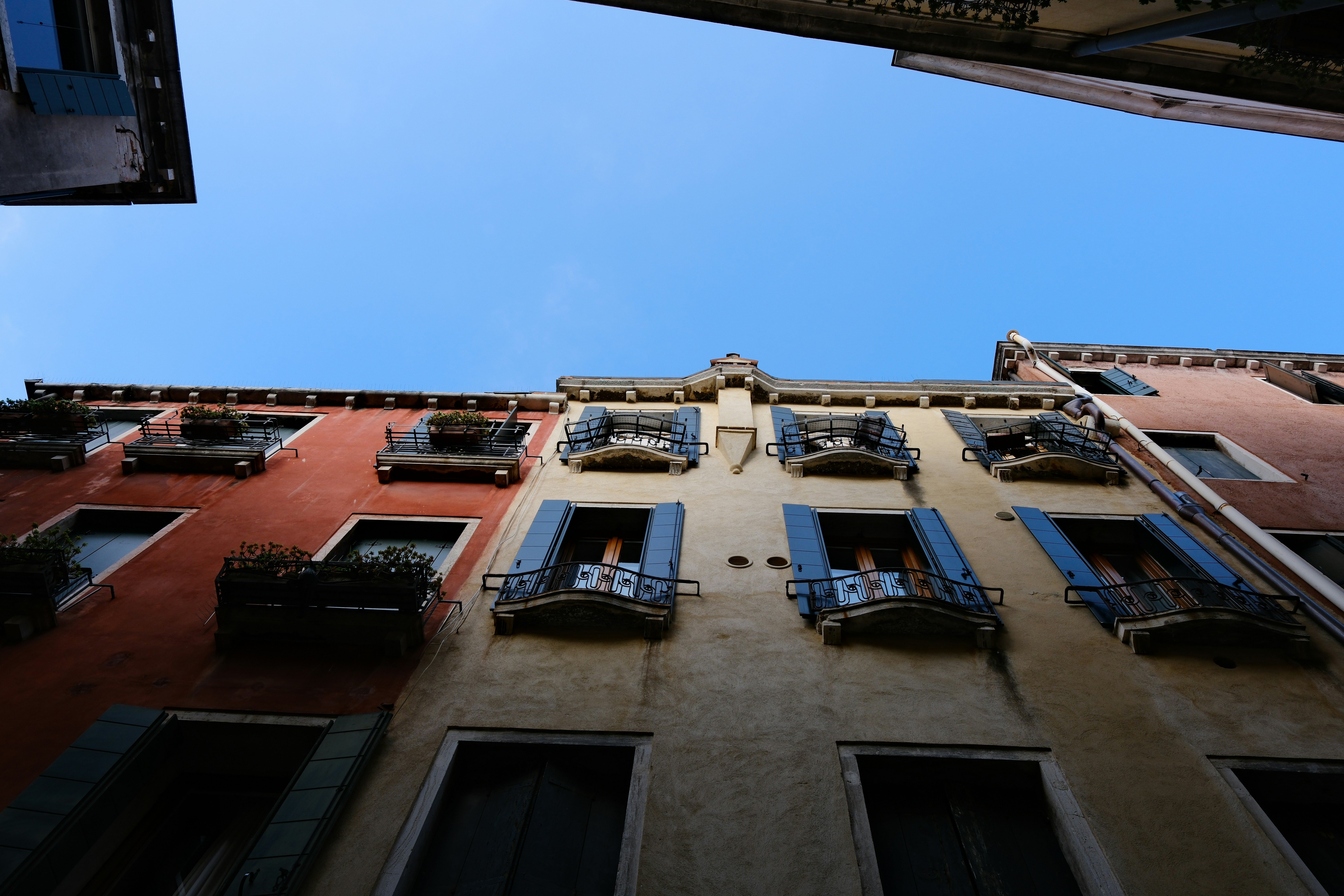 Skyward Facades: A Street of Painted Stucco and Iron