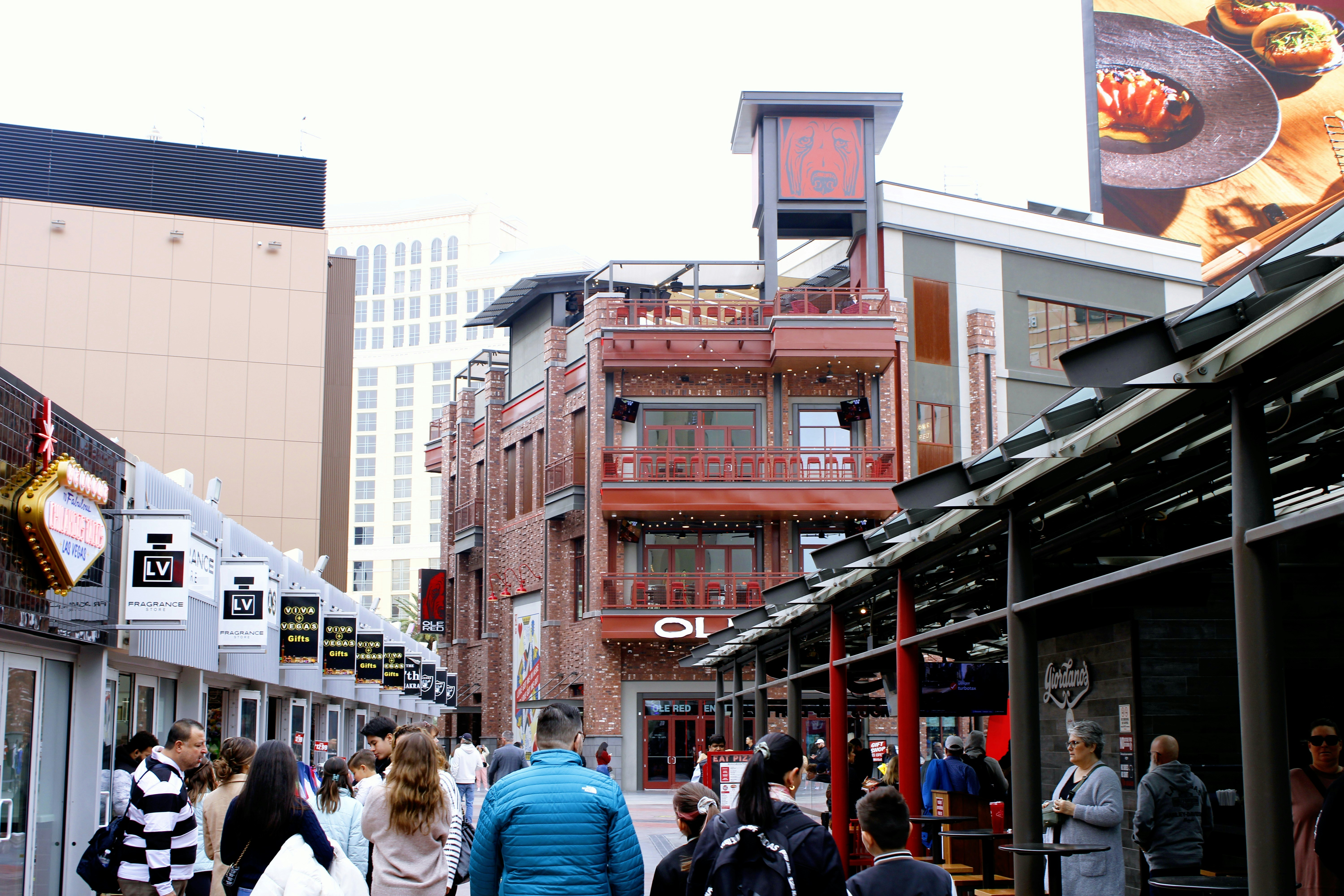 People walking down a bustling street with shops.
