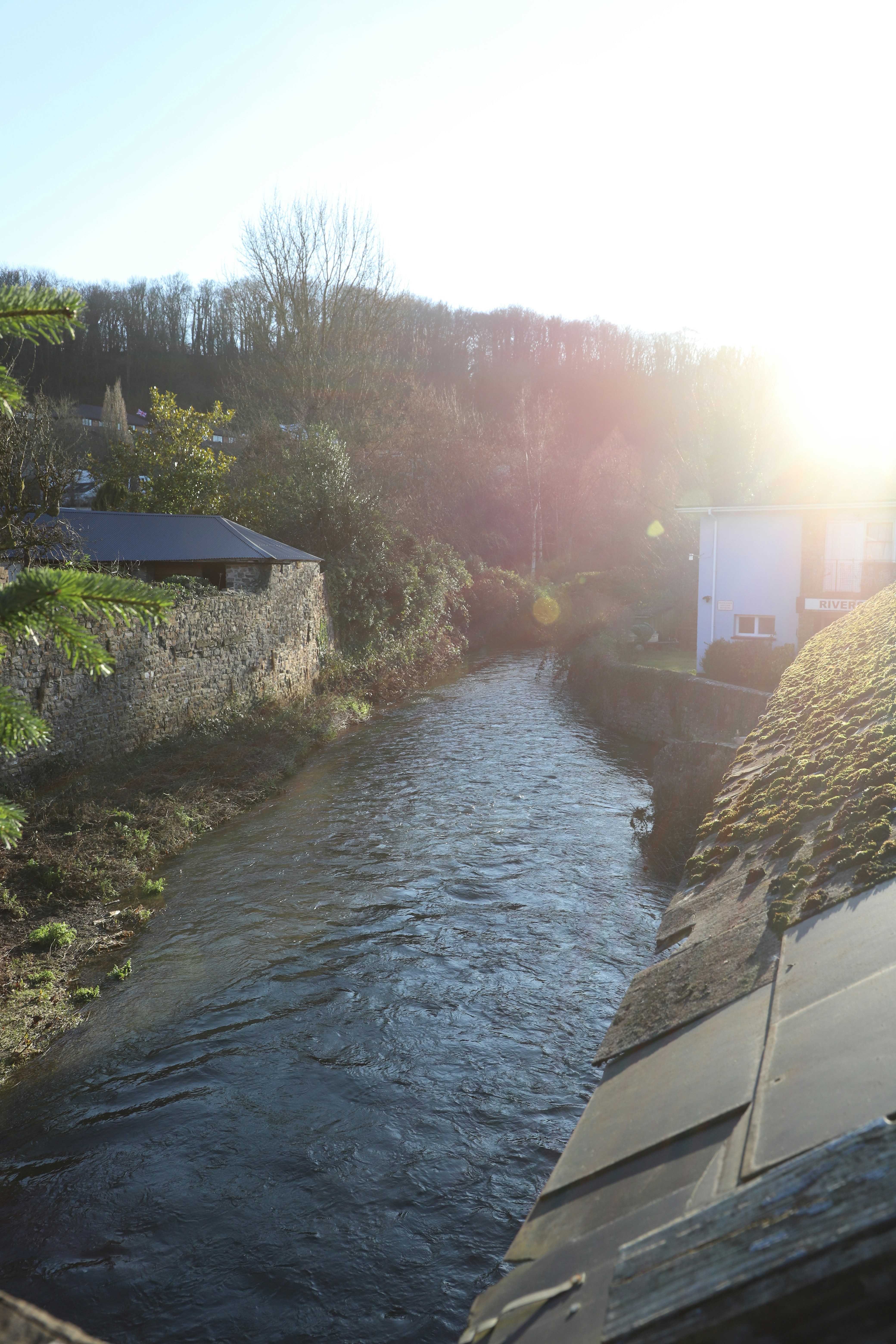 Sunlit River Channel Bordered by Stone Walls