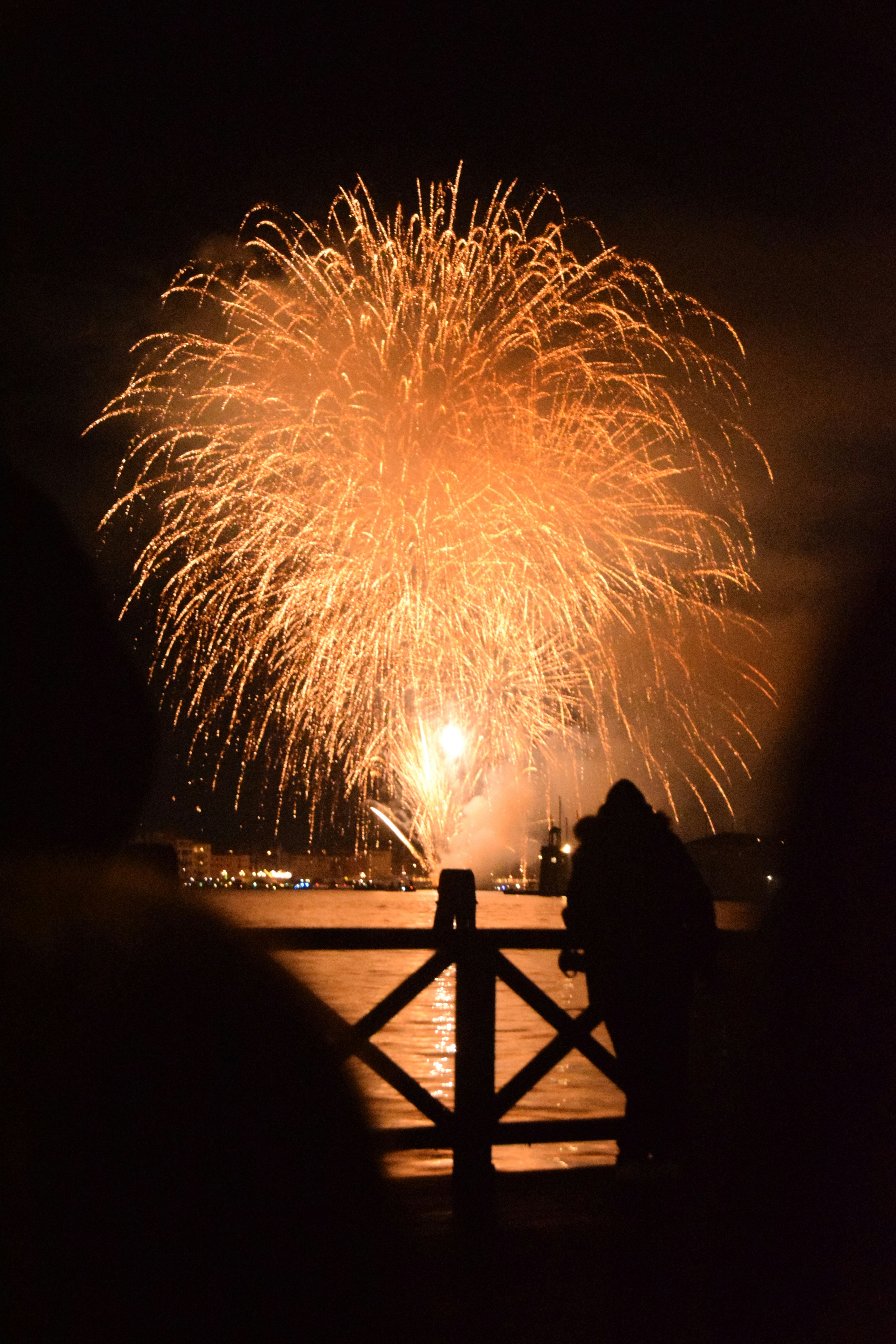 Fireworks Over the Pier: Nighttime Celebration Framed by silhouettes