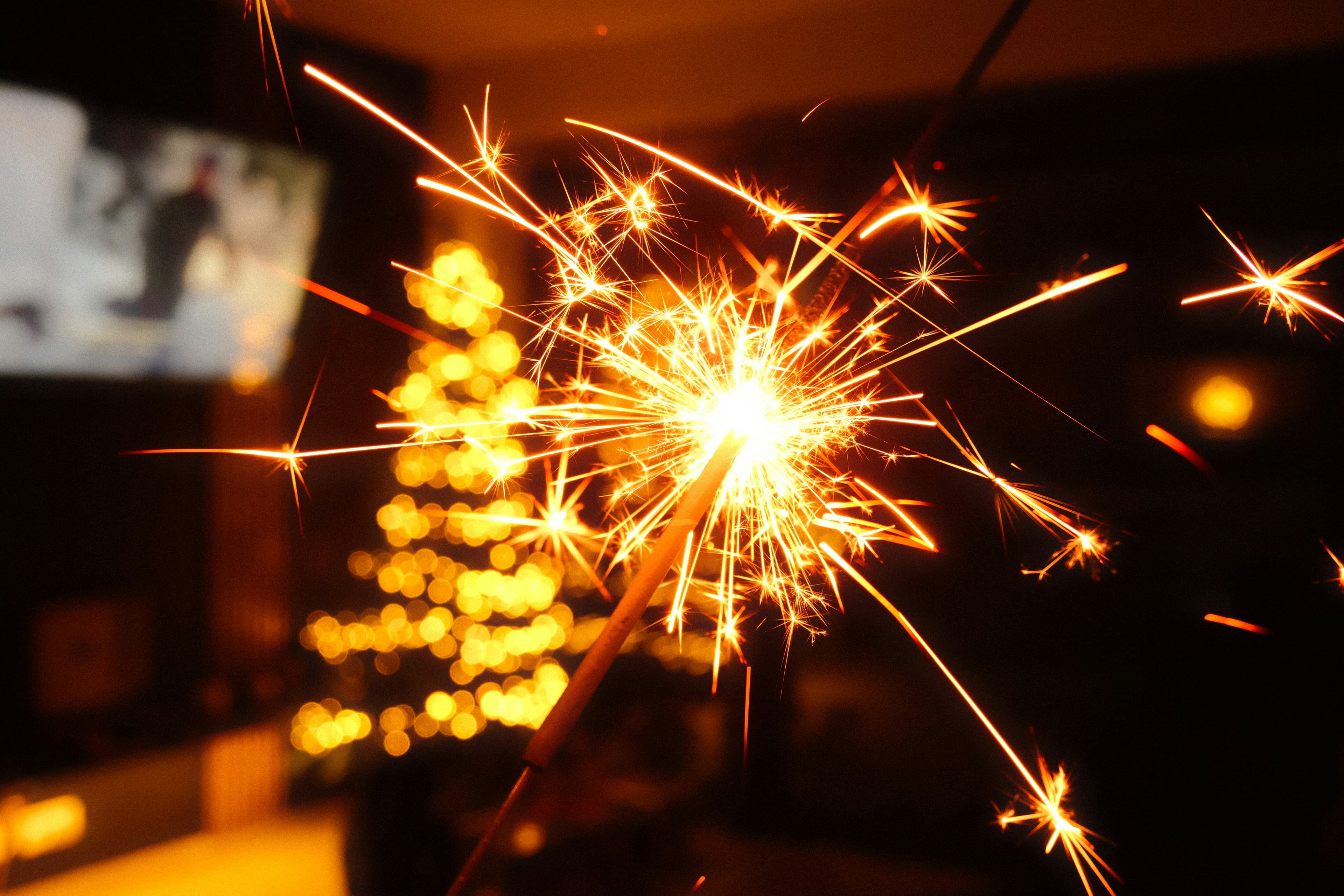 Spark of Celebration: a close-up of a handheld sparkler against a softly glowing holiday backdrop